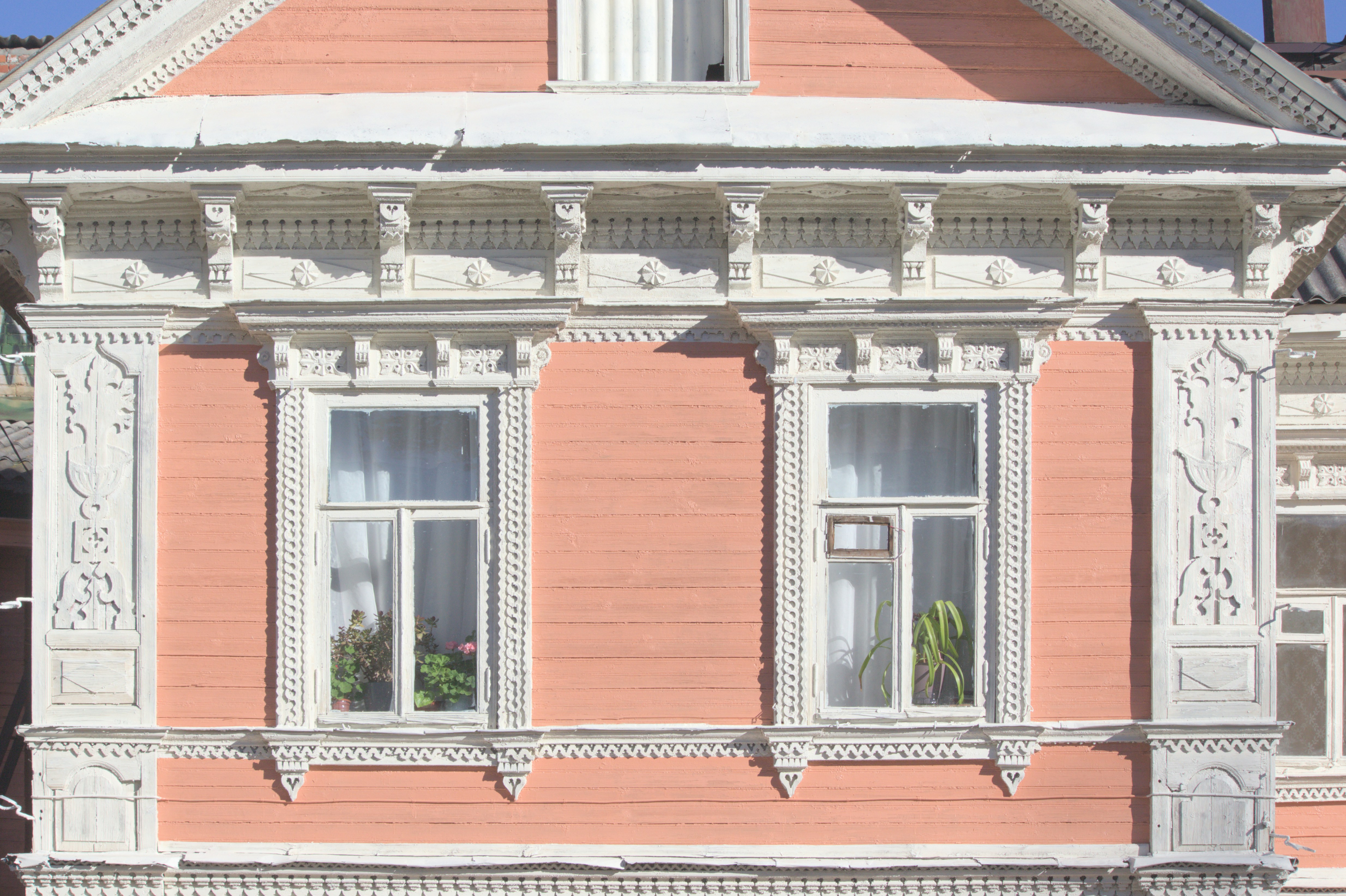 Ornate Facade in Soft Coral: A Quiet Facade with Windows and Sculpted Friezes