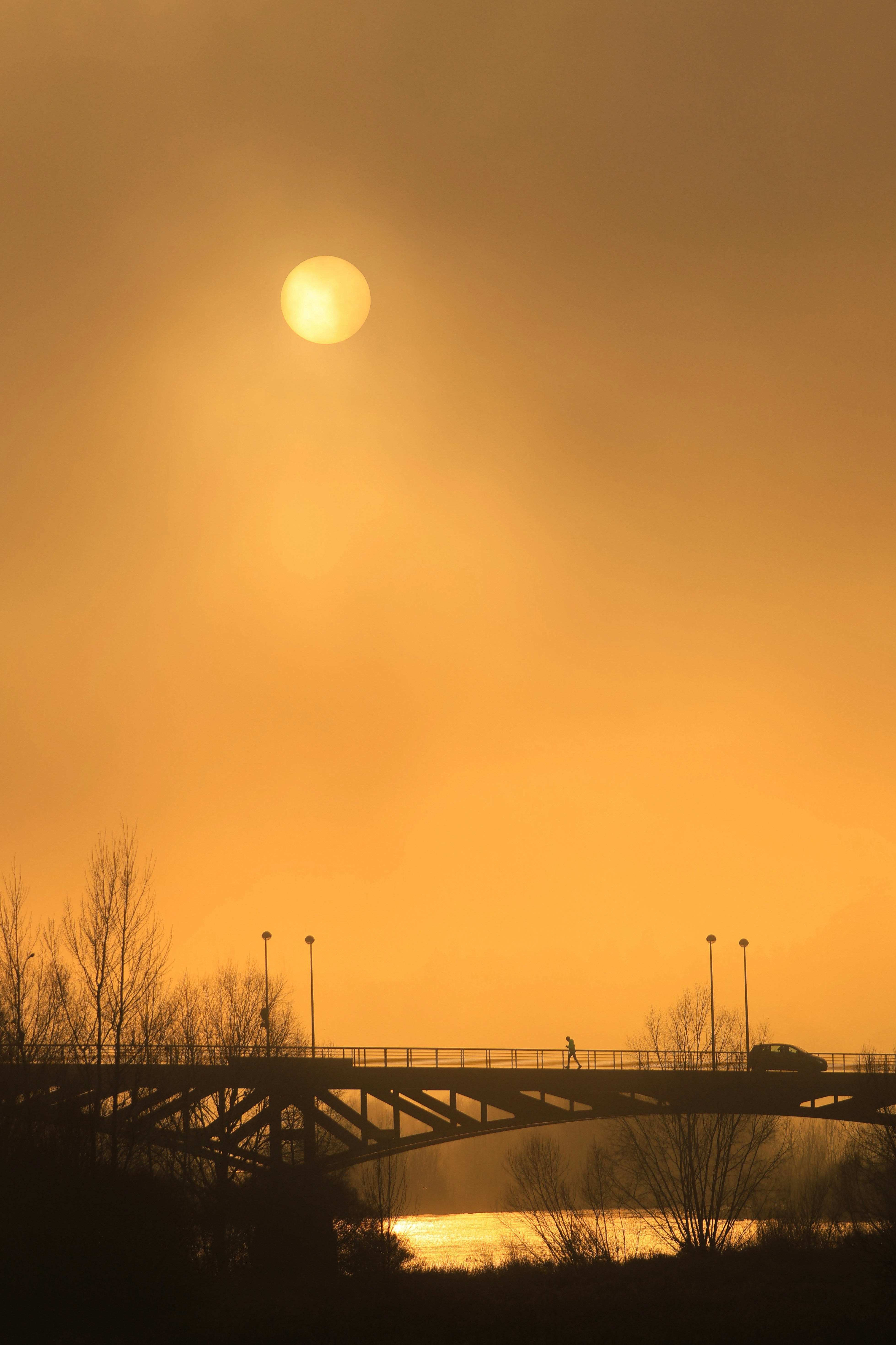 Sunlit Quiet: A lone walker Trace on the Bridge at Dusk