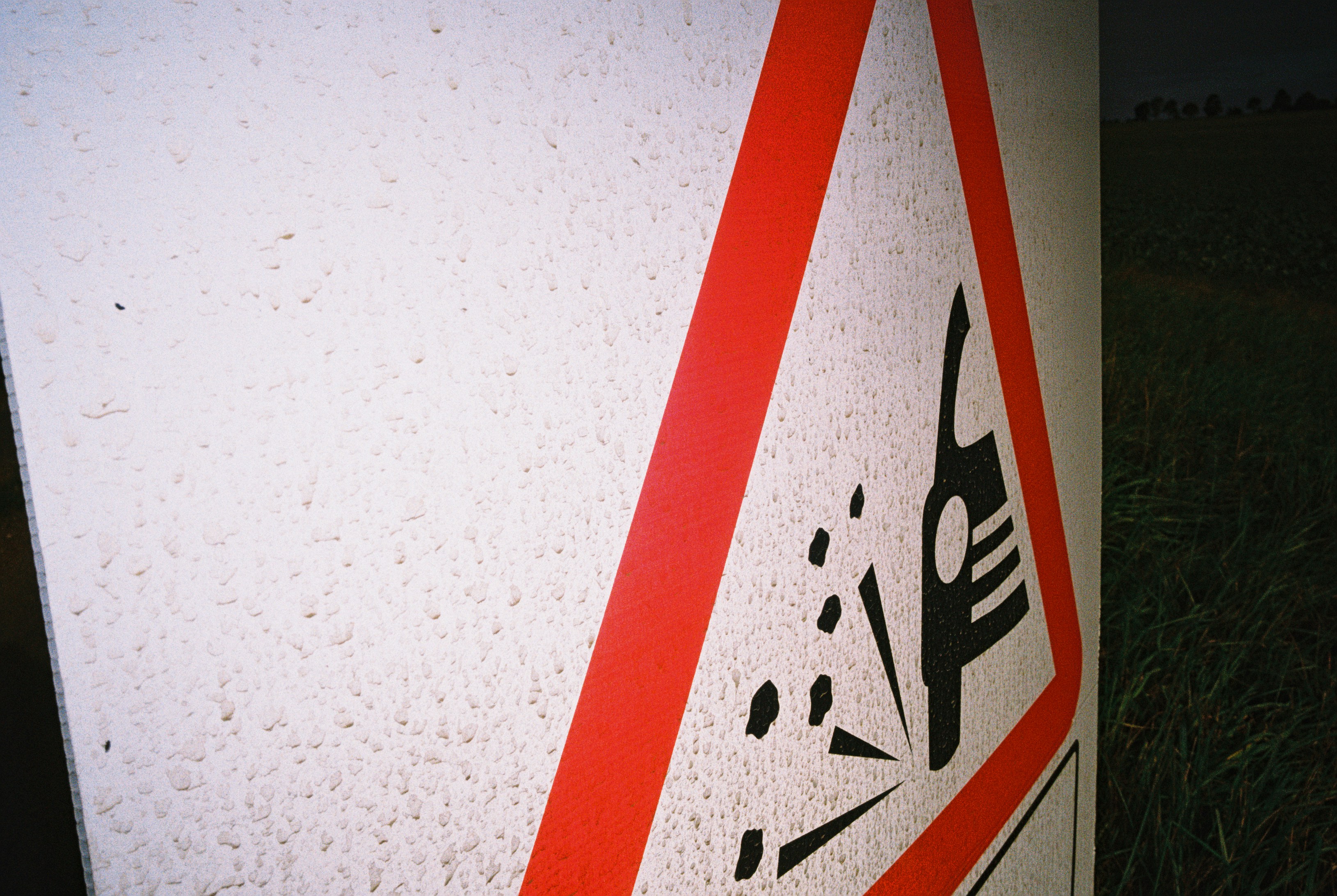 Tilted Warning Sign: Red Border and Fragments in a Field