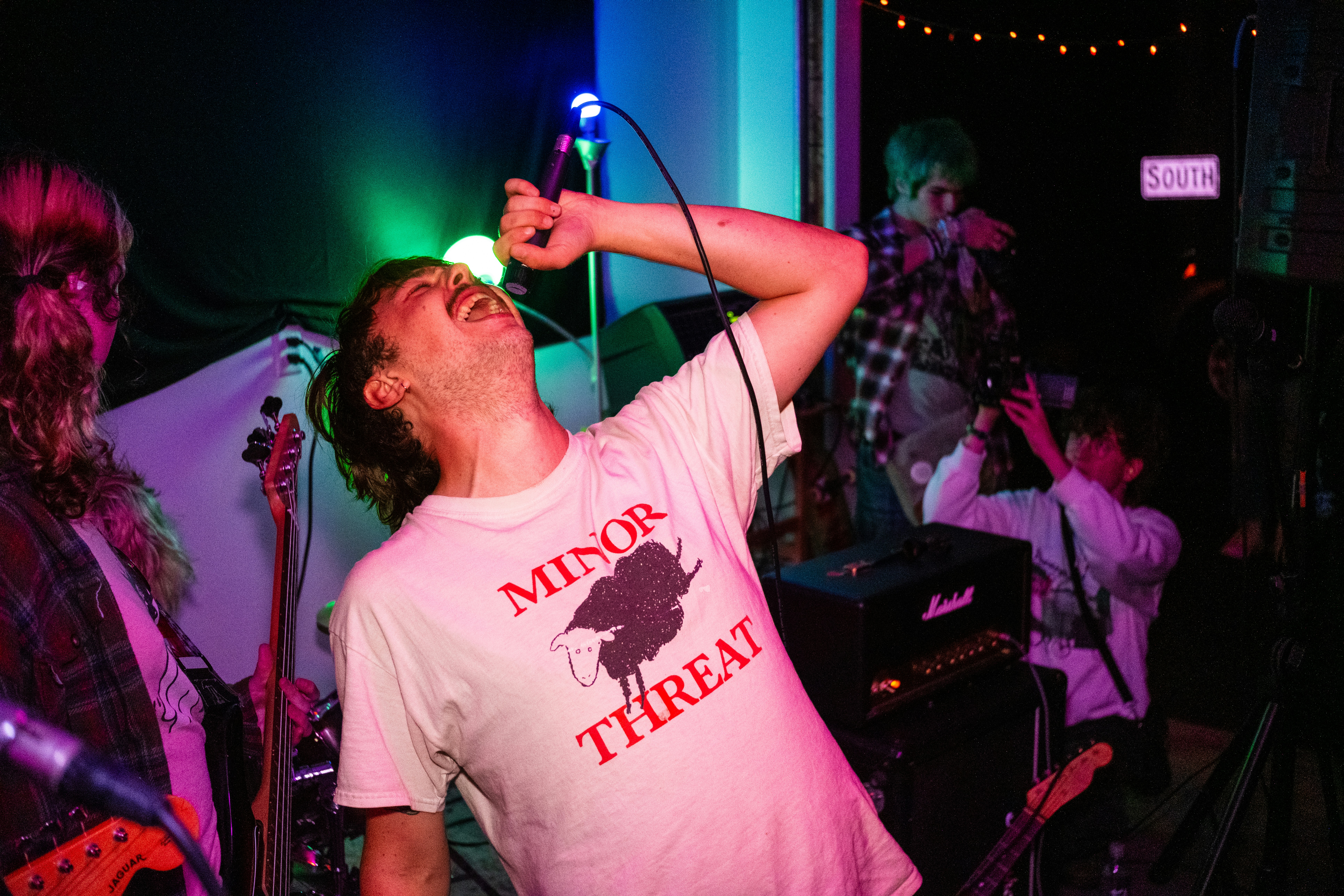 Mid-Song Shout: A Frontman Bellowing into the Spotlight