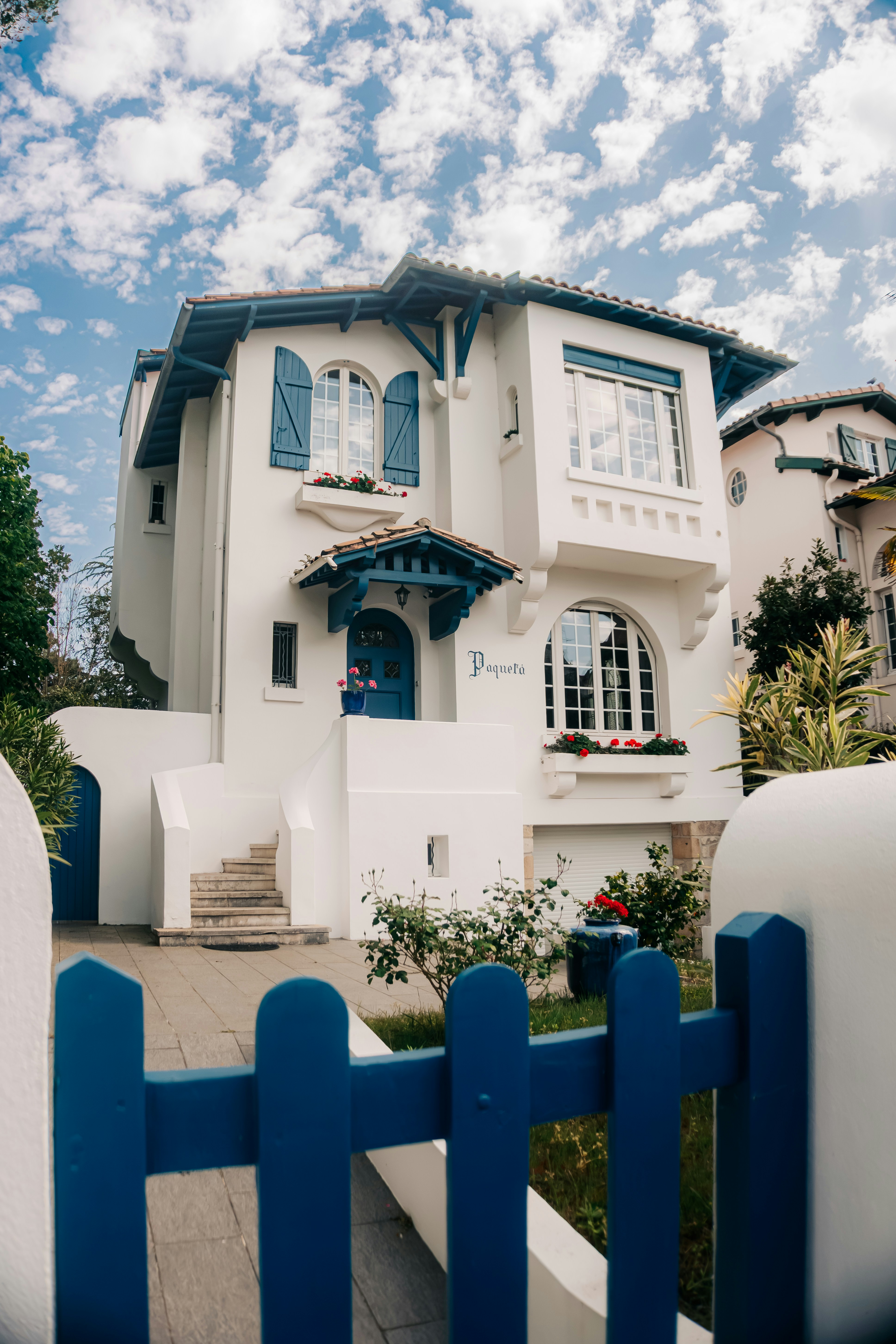 White Mediterranean Villa with Blue Accents and Garden Gate