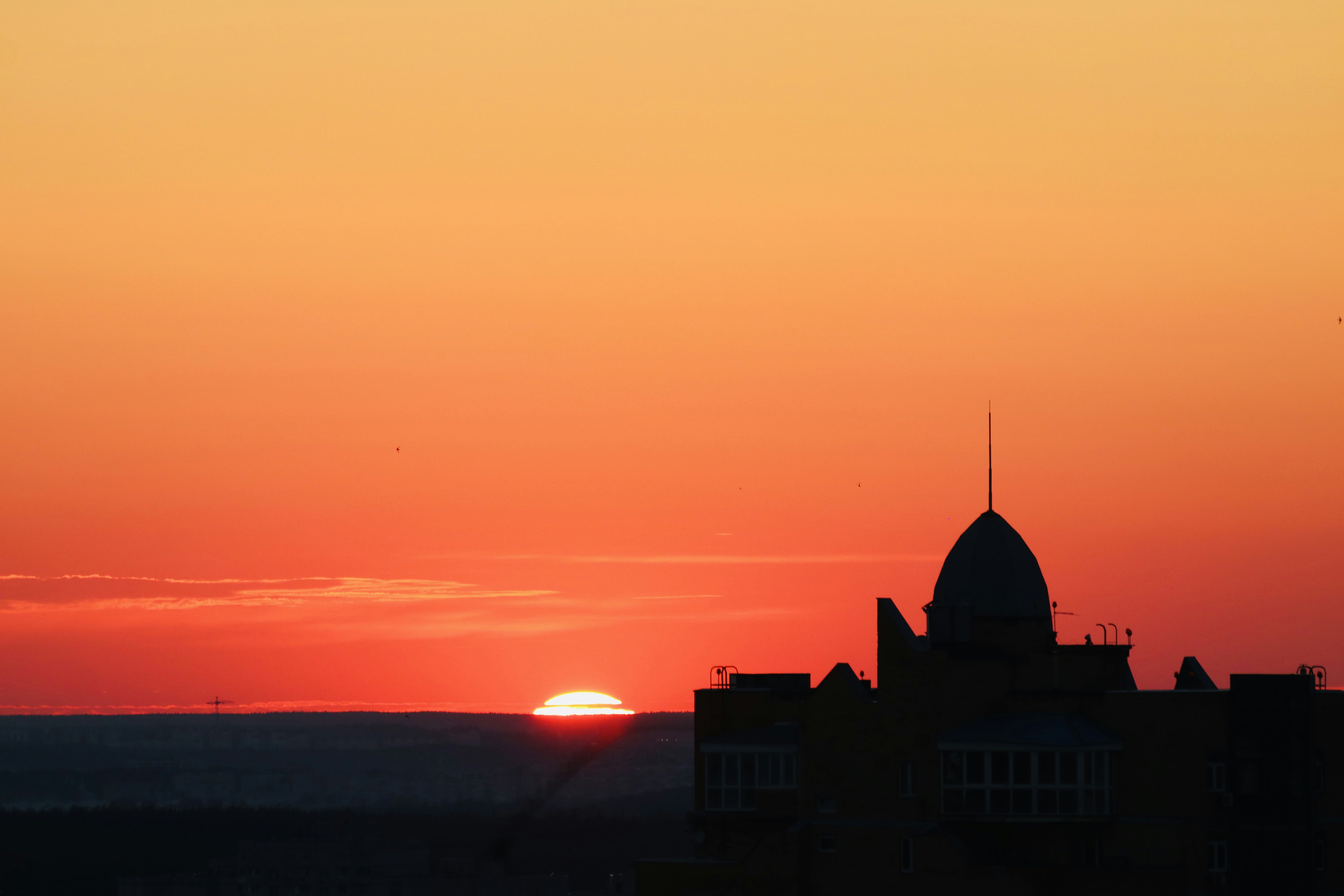 Silhouette at Dusk: The Dome’s Quiet Edge Against a Crimson Horizon