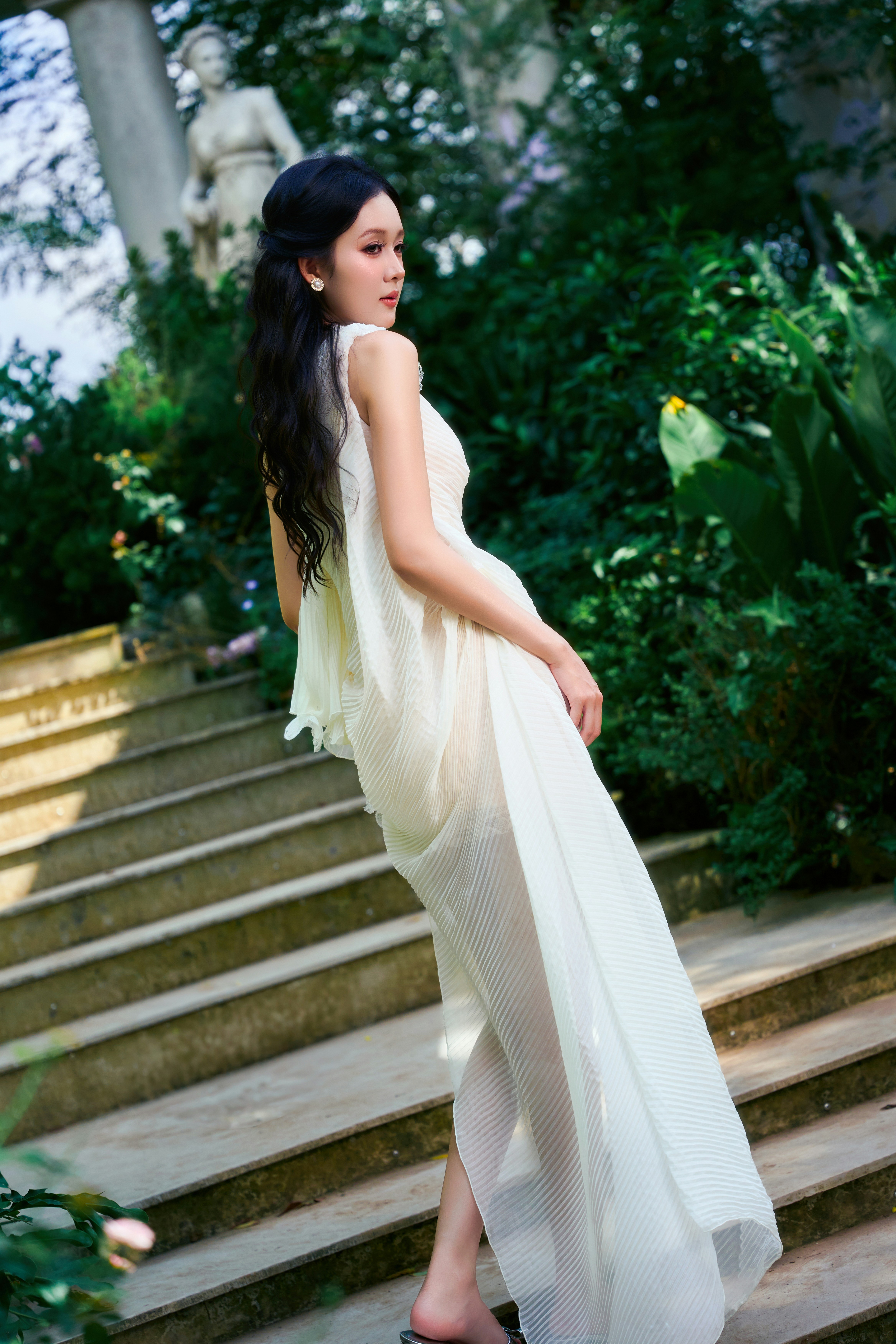 Elegance on Stone Steps: A White Gown in Quiet Garden Reverie