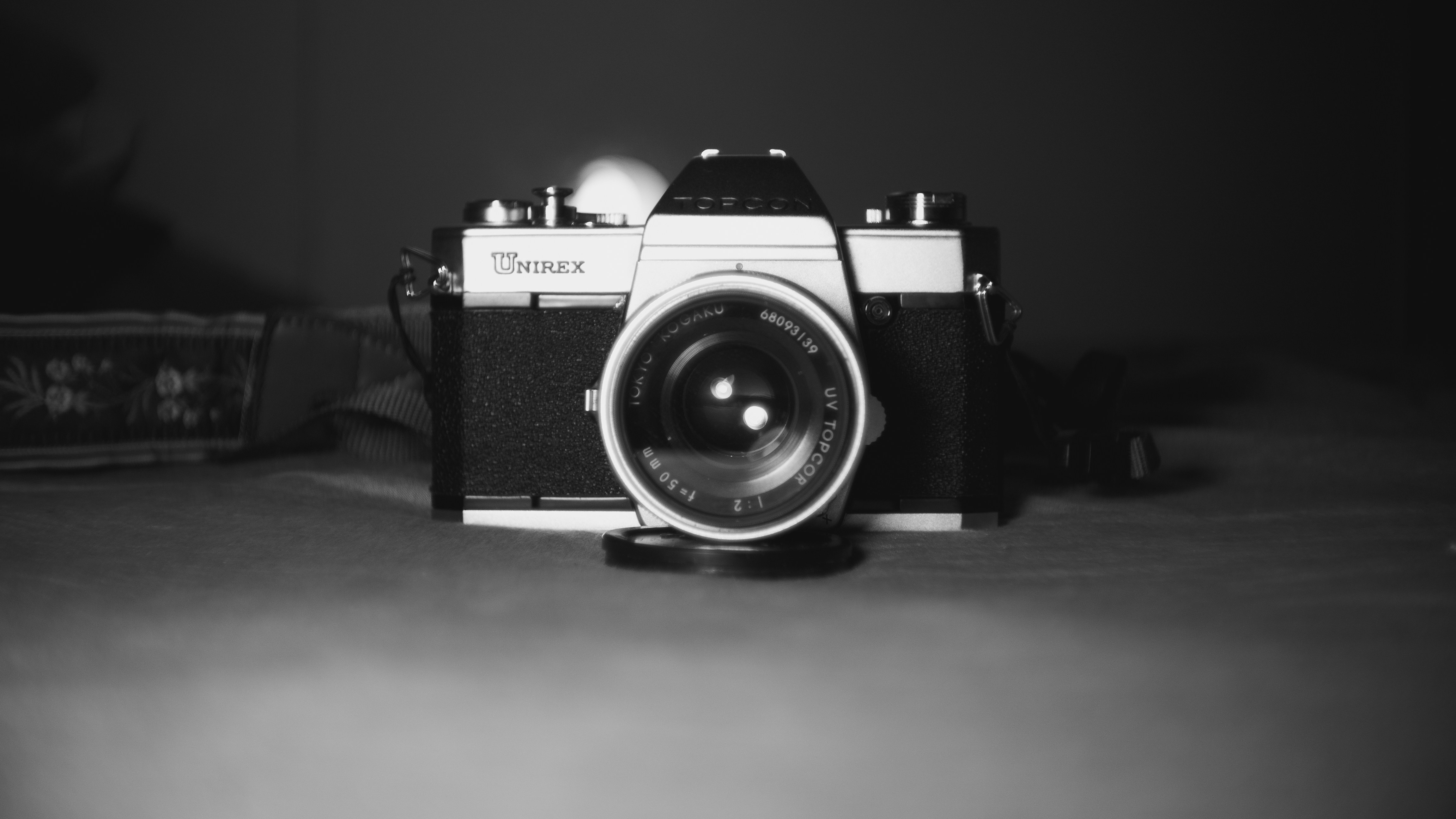 Vintage Focus: A classic film camera rests on a soft, dim-strewn surface