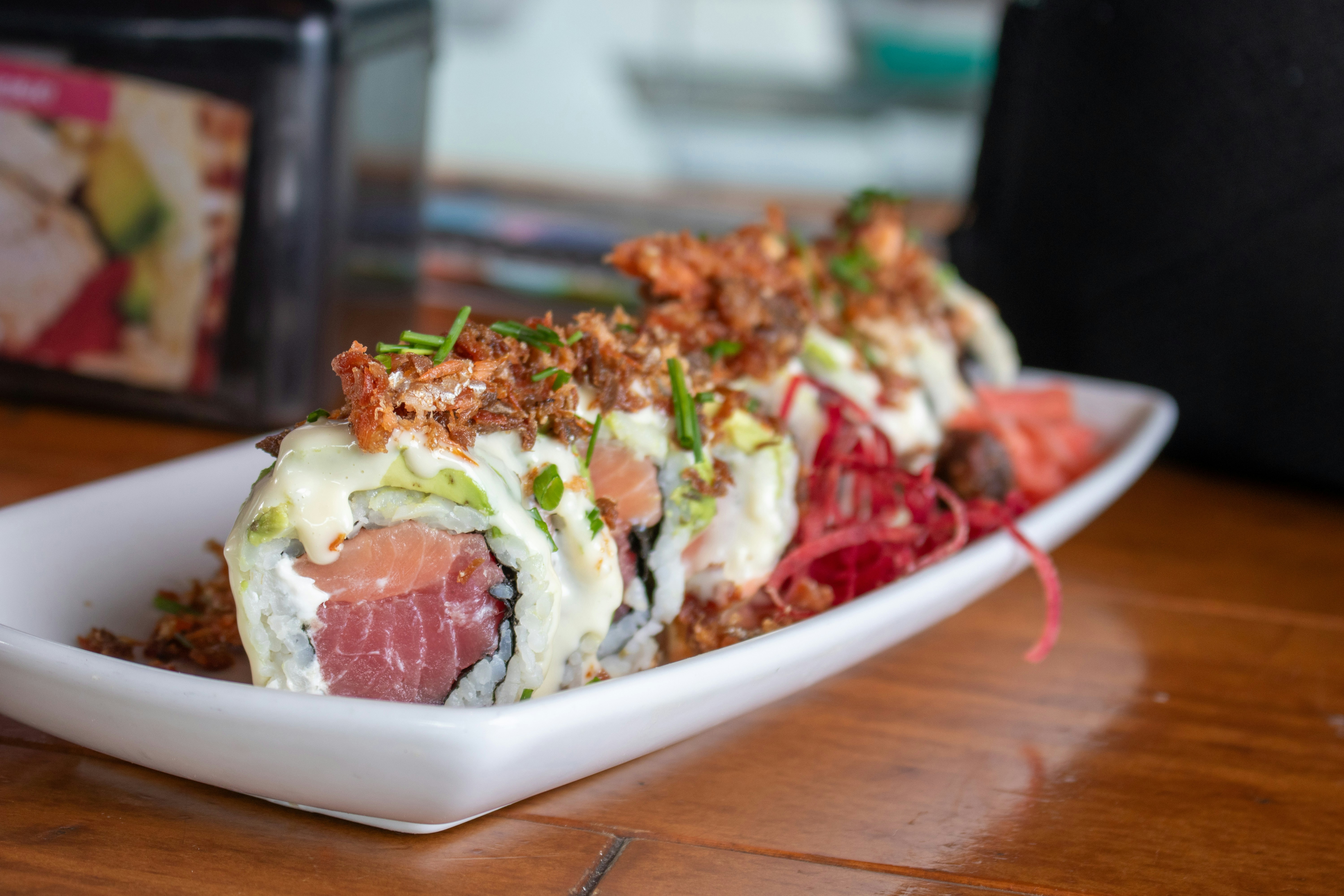 Rolled Symphony: A Plate of Crispy-Topped Sushi Drifting in Focus