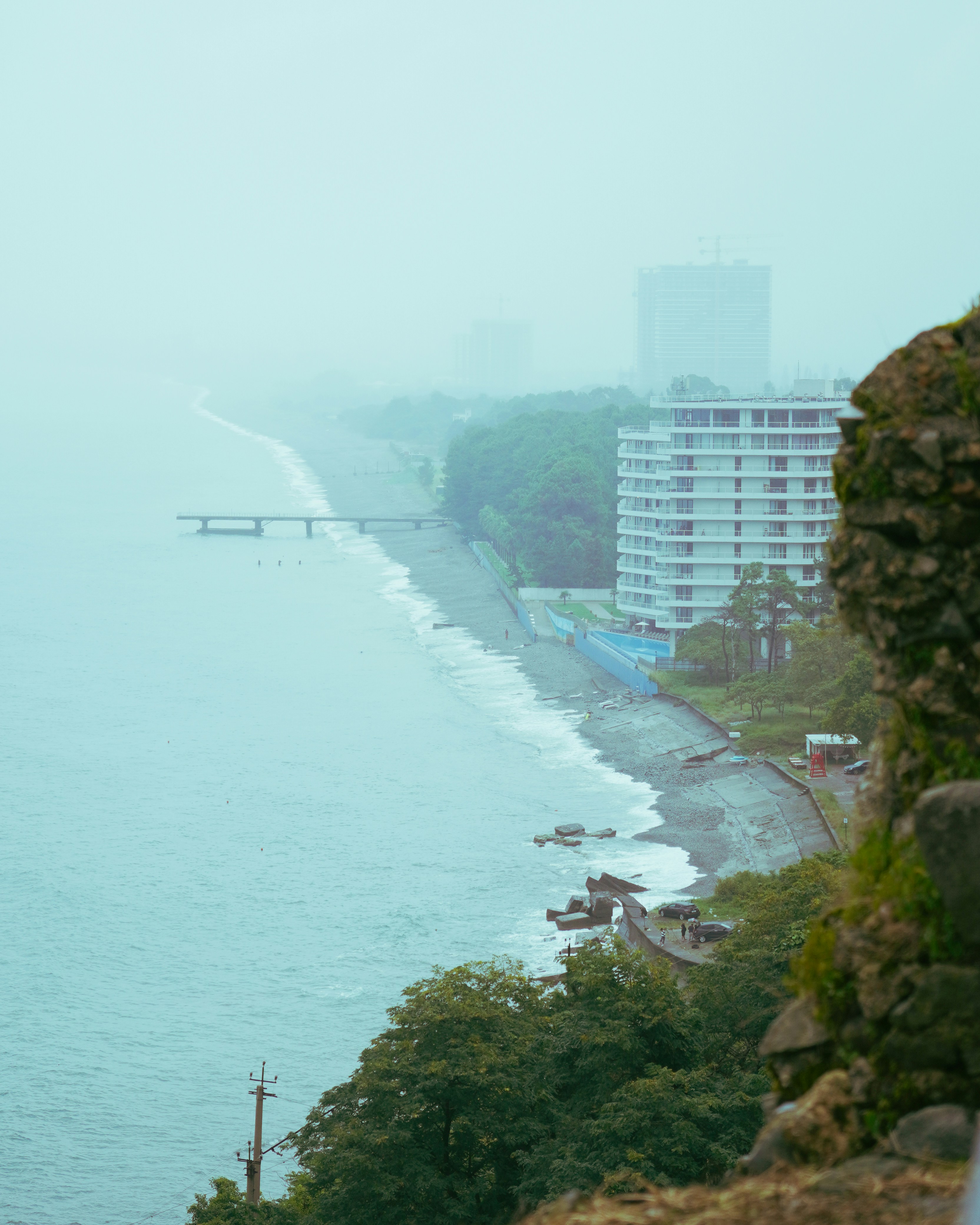 Fog-bound Seaside Edge: A Quiet Coastal Arcade Framed by Cliff and Towers