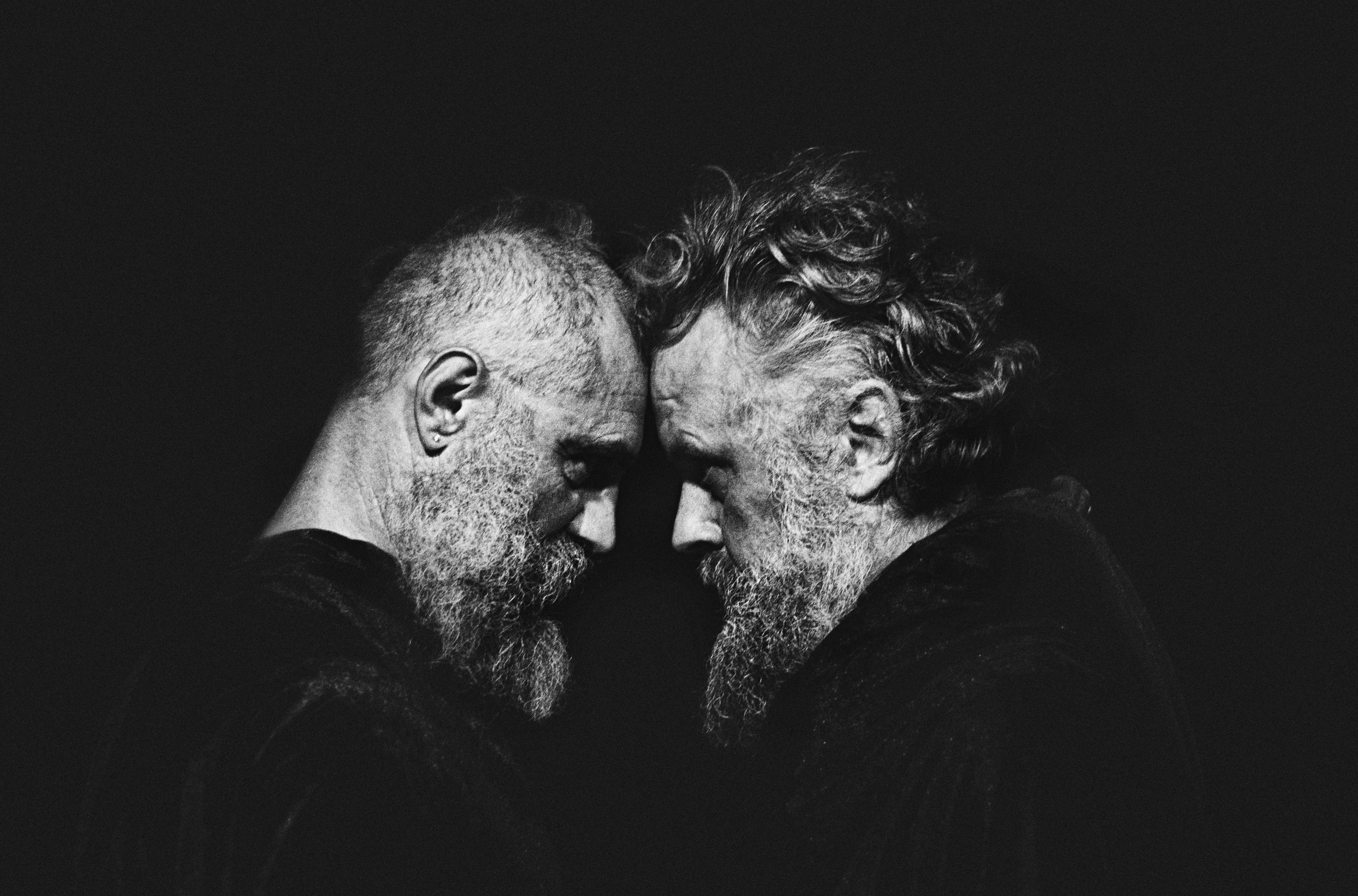 Two Warped Echoes: Dual Bearded Silhouettes in Quiet Confrontation