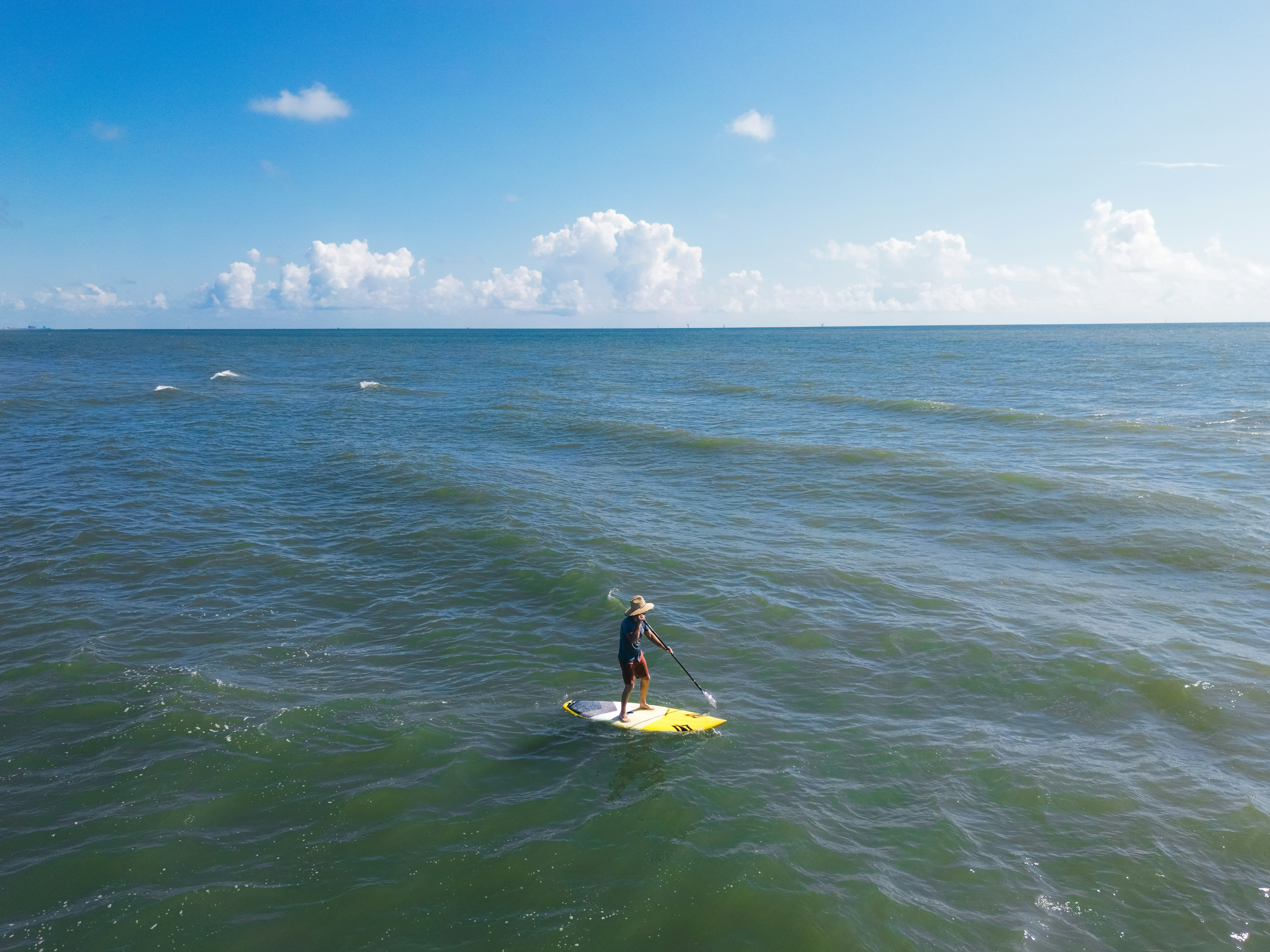 Solitary Paddle: A Stand-Up Moment Upon Blue Expanses