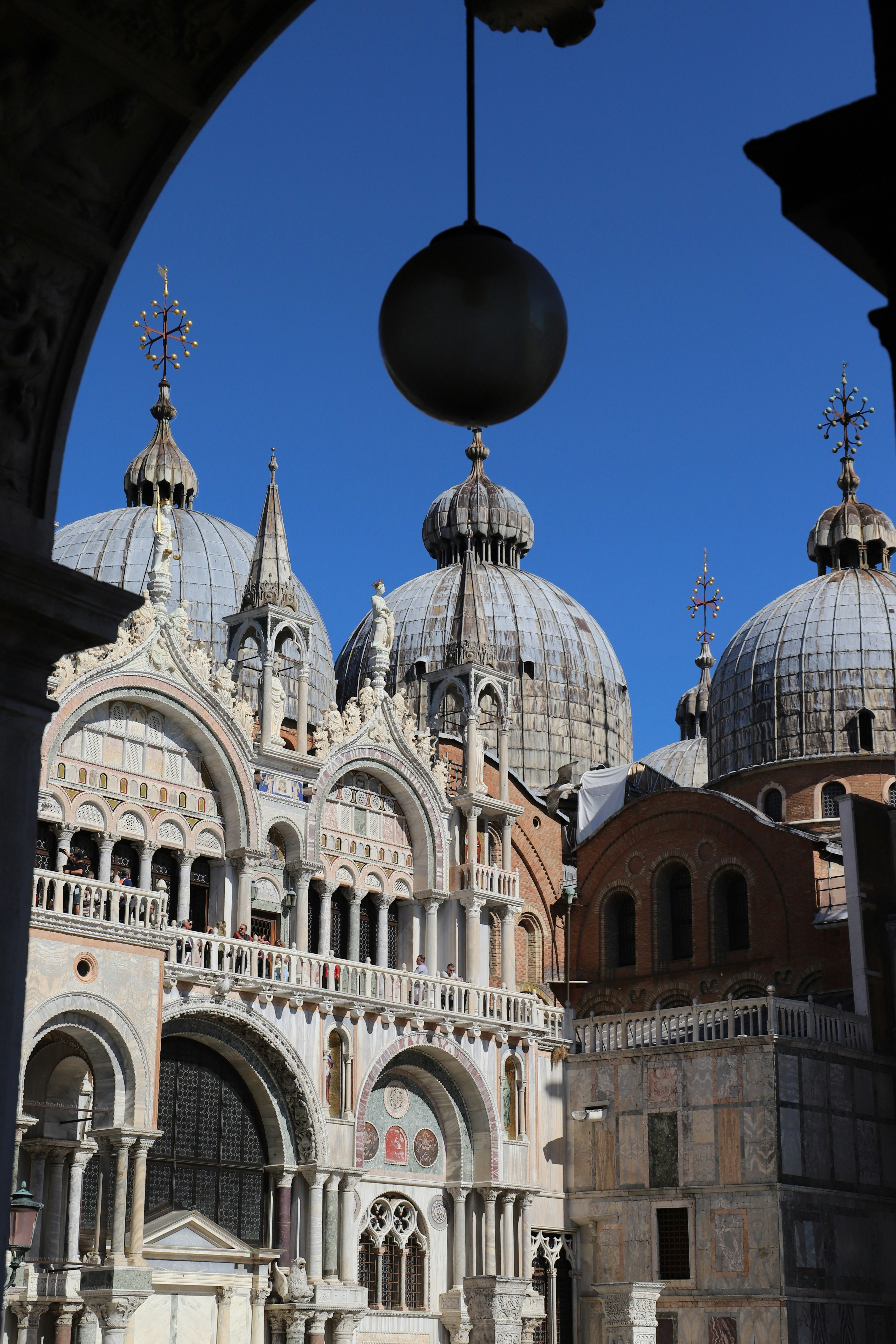 The ornate domes and arches of St Mark's Basilica in Venice under blue sky