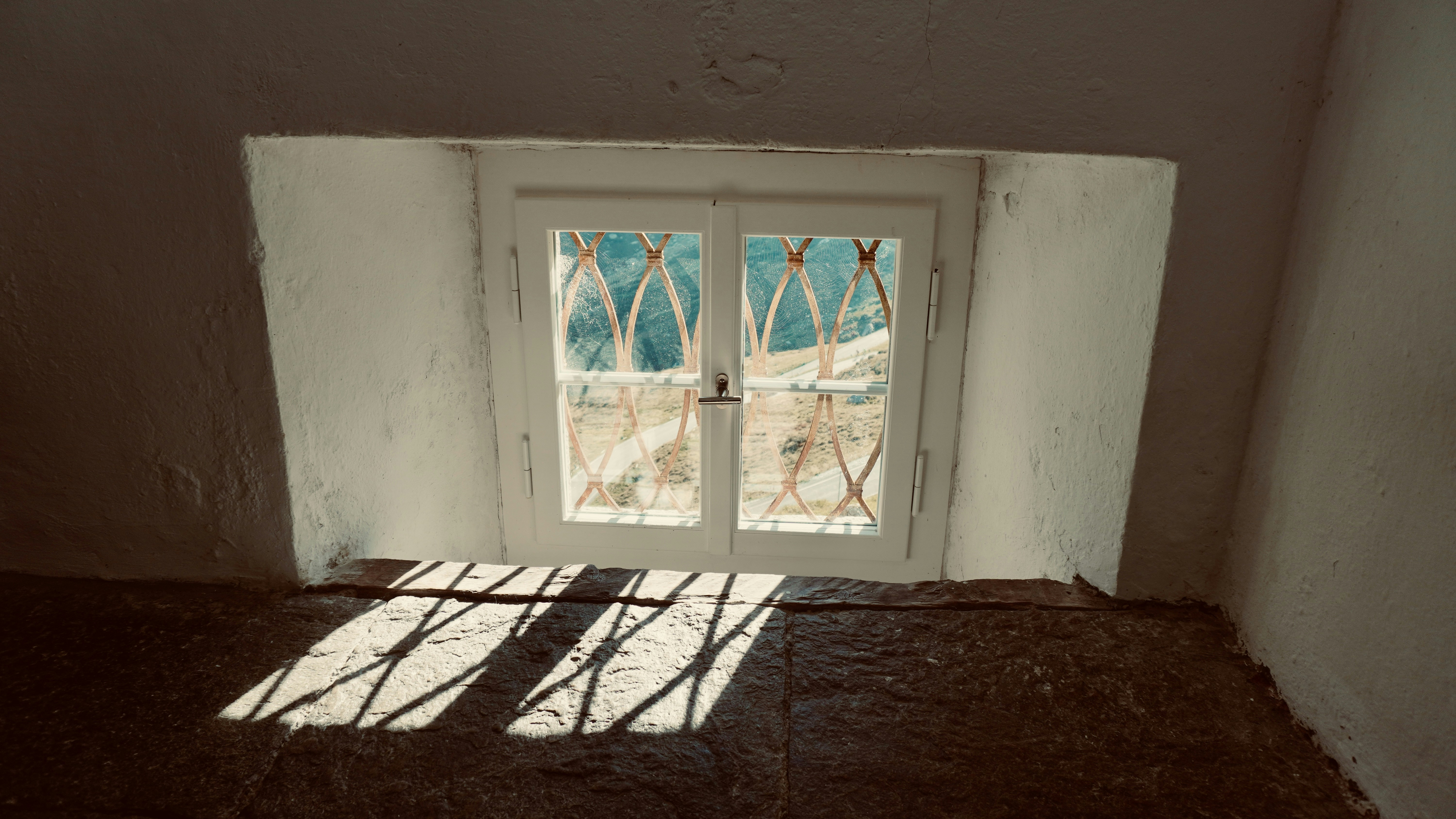 Sunlit Window Grilles Casting Latticed Shadows Across a Dim Room