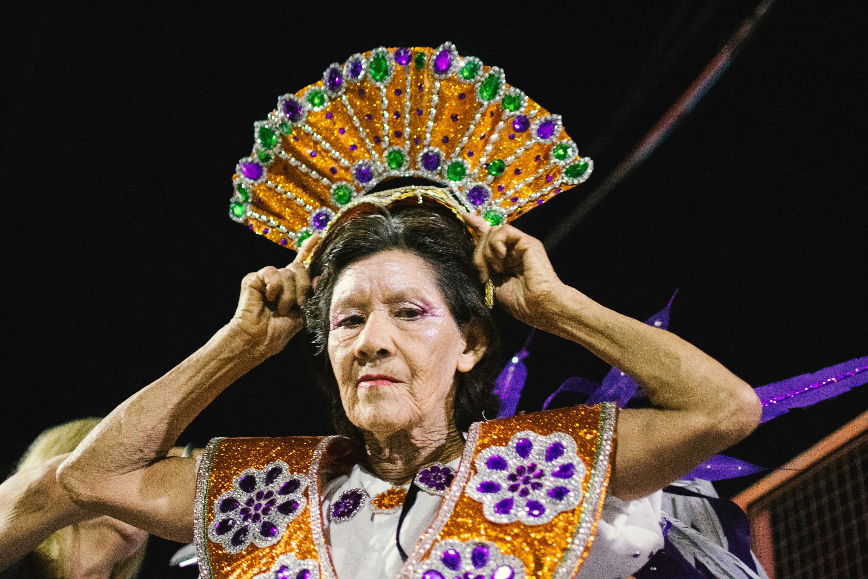 Regal Headdress Rise: A Veteran Performer in Ornate Carnival Attire