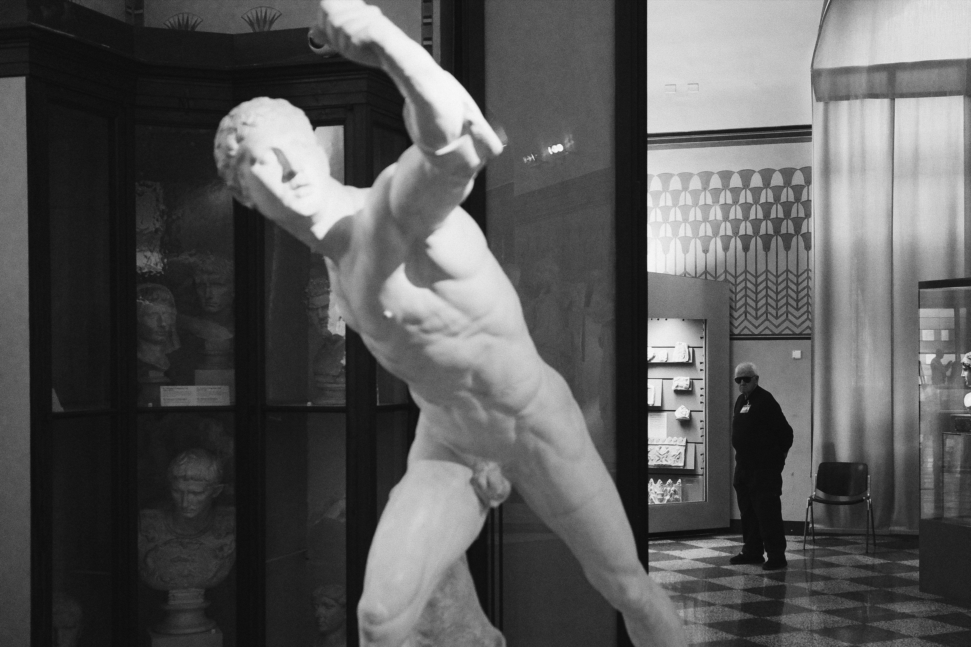 Concrete Reverie: Statue in a Glassbox Within a Modern Gallery