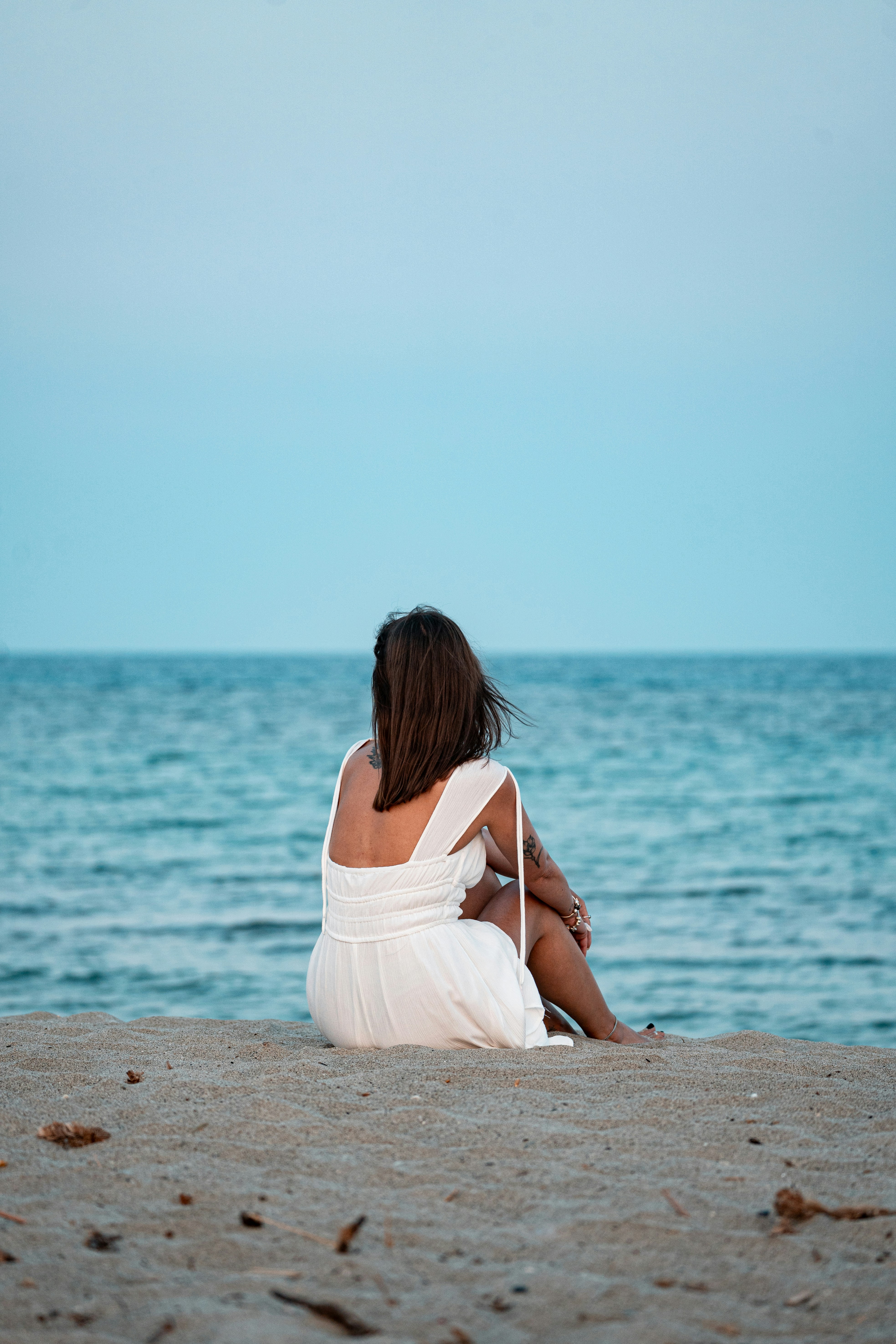Solace by the Shore: A Sleeved White Dress at Dusk