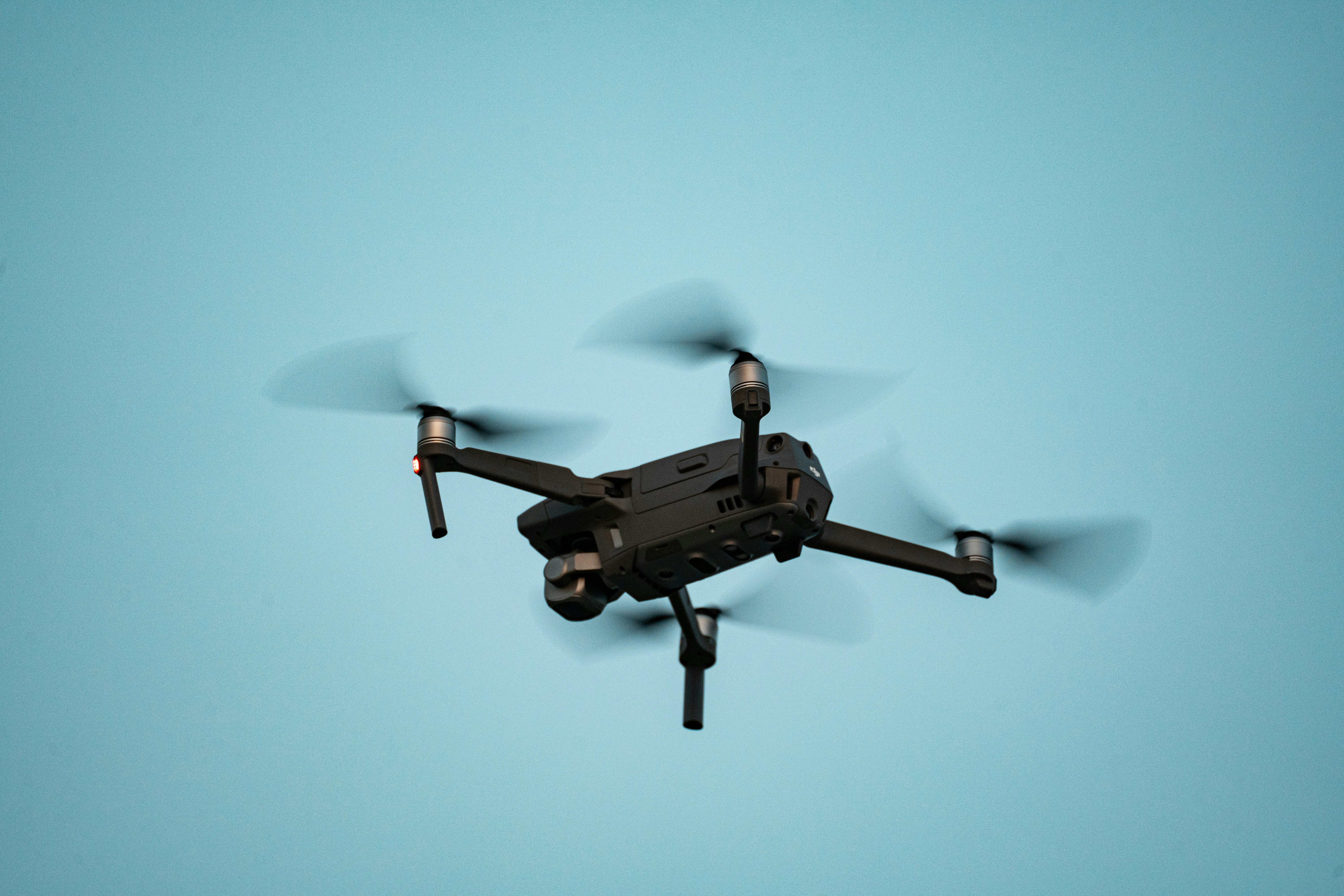 Motion in Quiet Blue: A Quadrotor Hovers Against a Cyan Backdrop