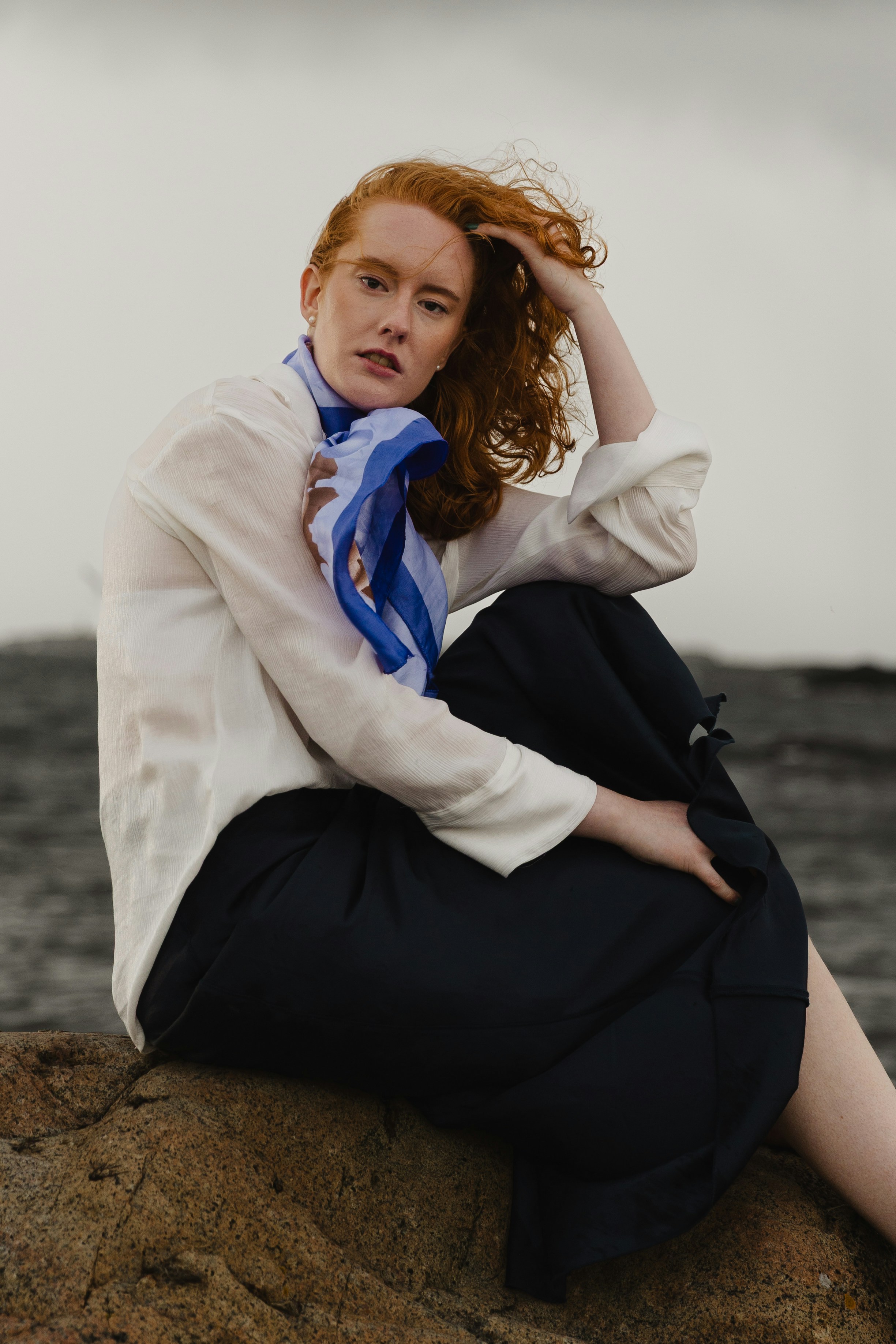 Red-haired quiet strength against a windswept backdrop
