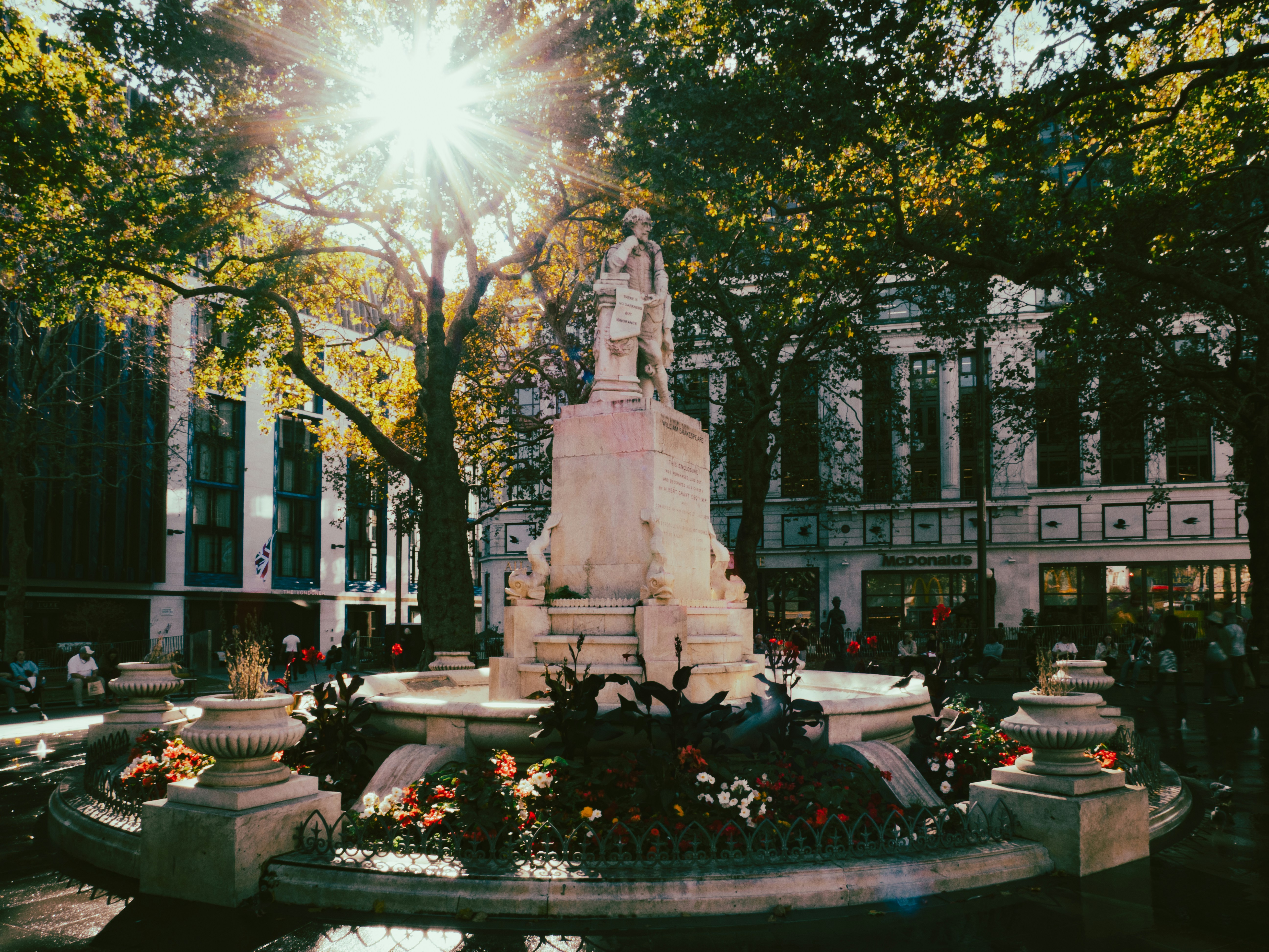 Sunlit Fountain Statue Amid City Arcades