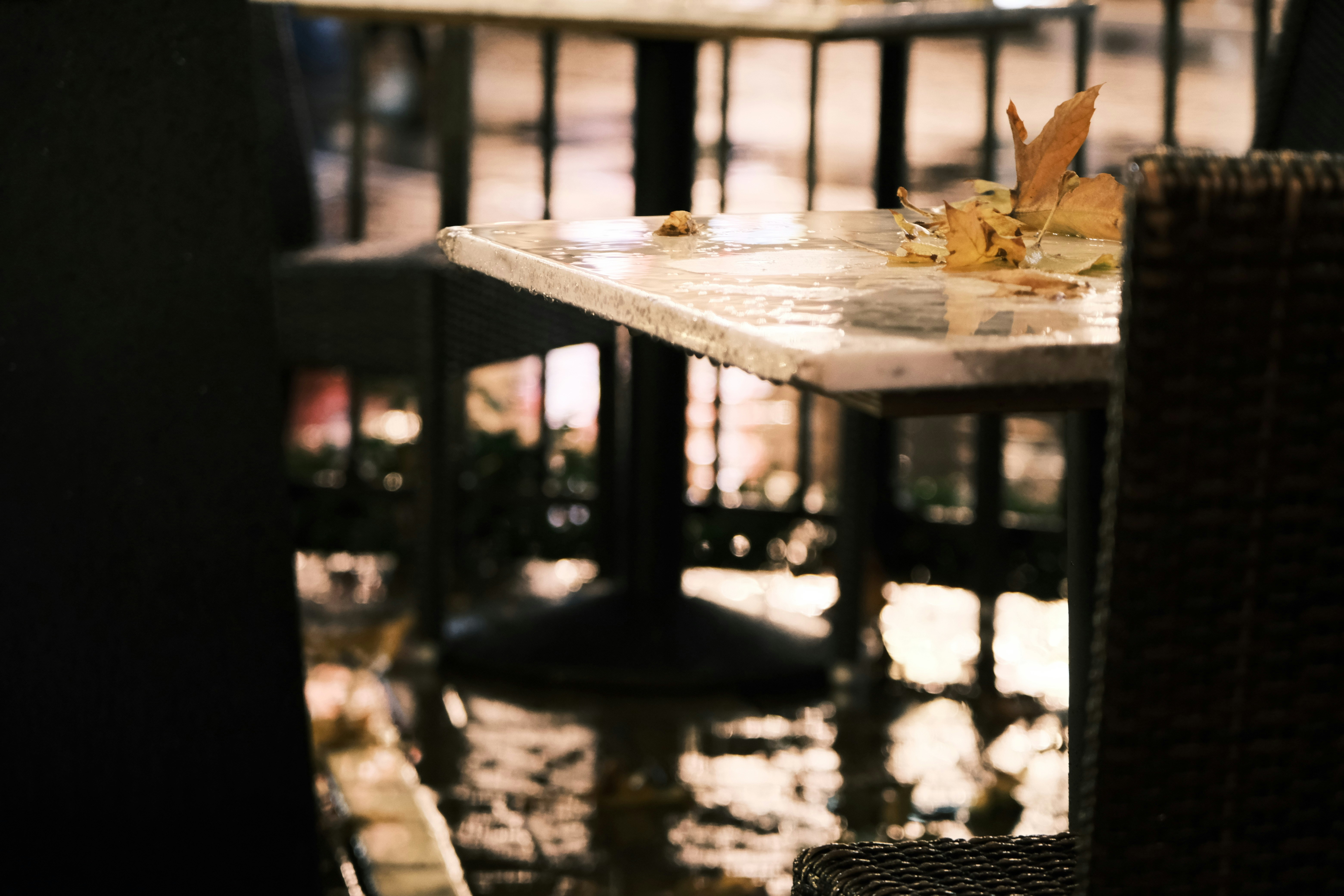 Sunlit Autumn Tabletops: Leaves on a Quiet Terrace at Dusk
