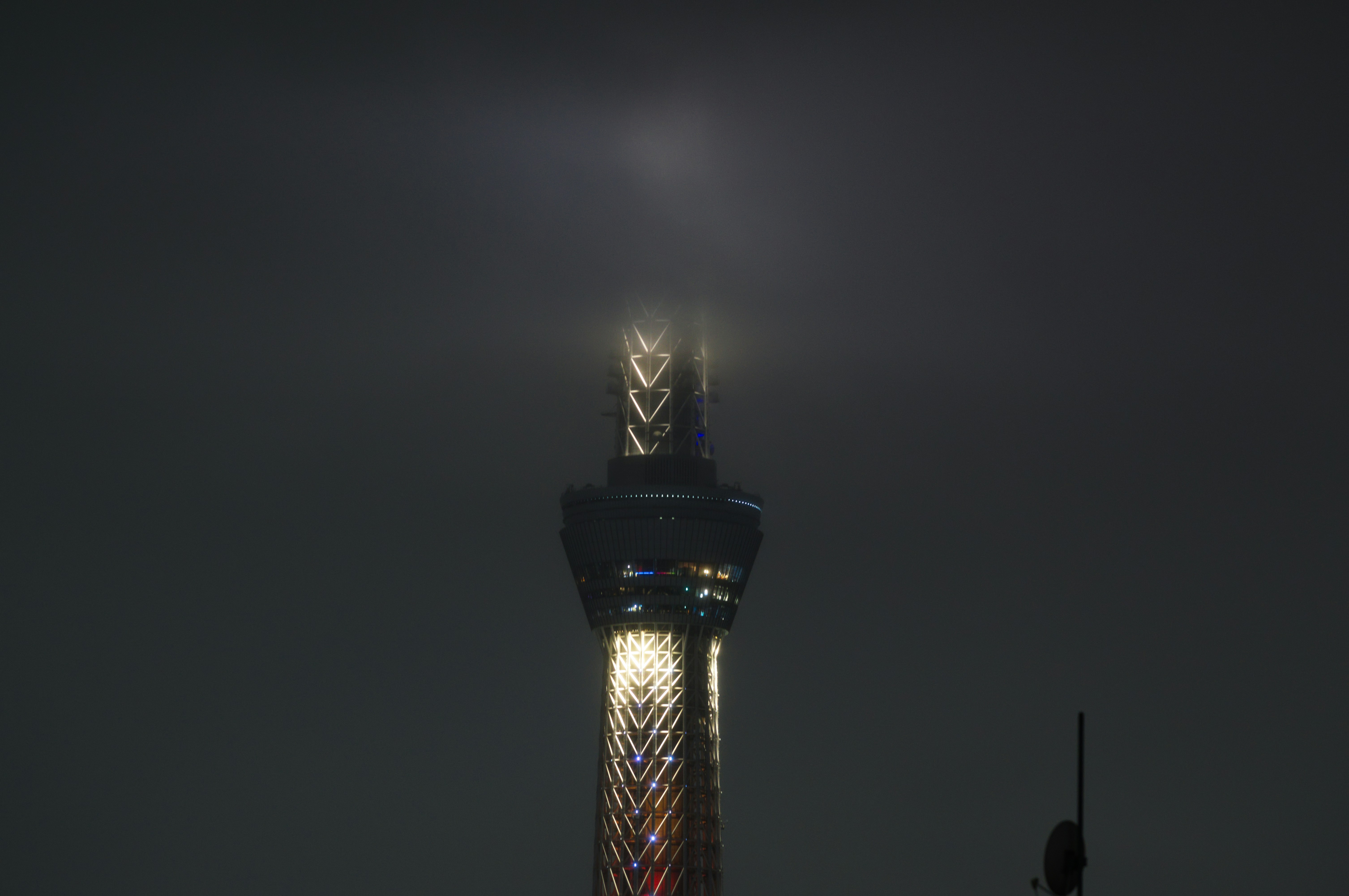 Luminous Spire Rising Through Night Mist