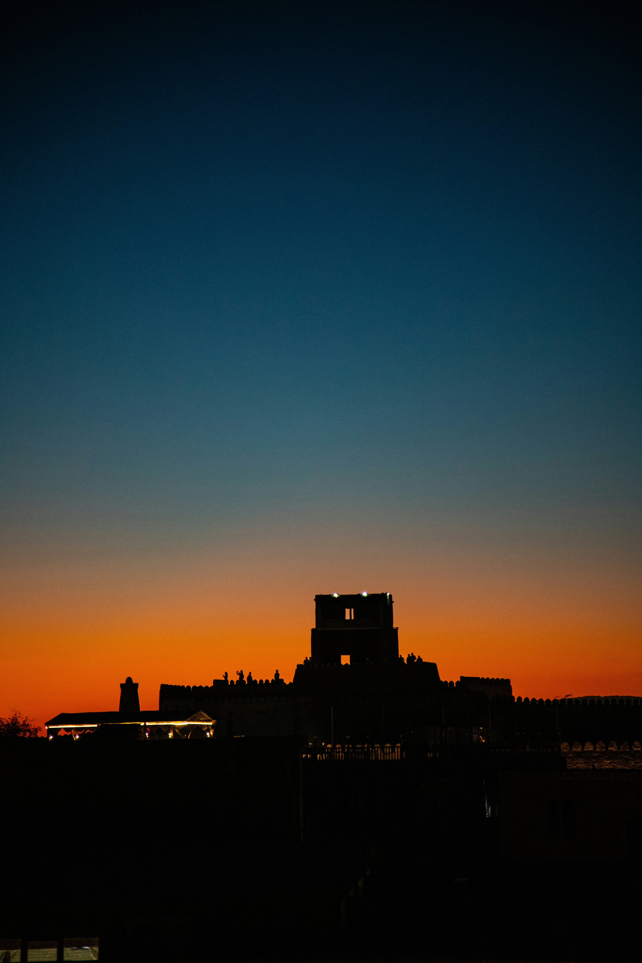 Silhouette of a fortress at sunset: calm gradient sky over ancient ruins