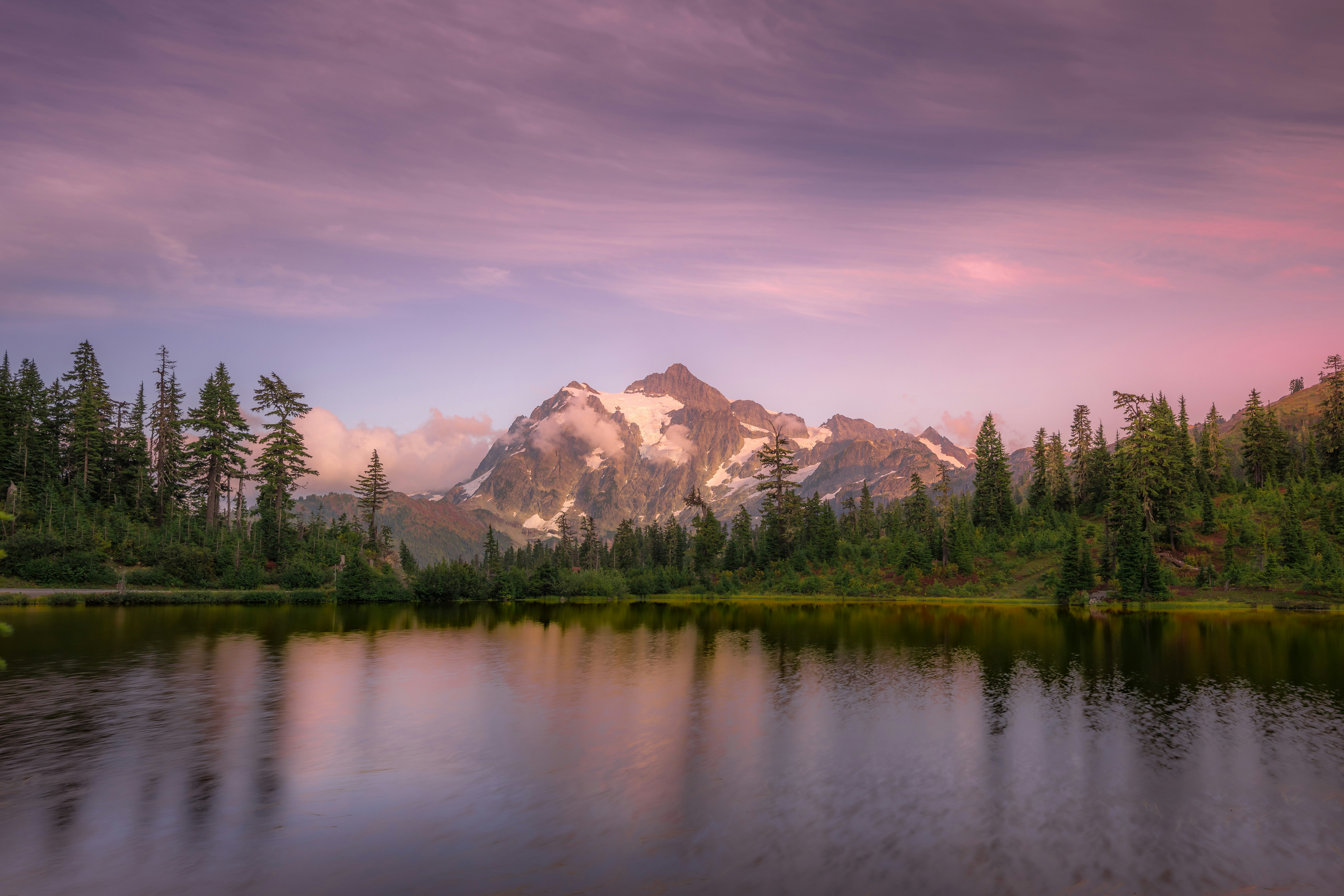 Majestic Basin at Dusk: Snow-Capped Peak Framed by Pine Border