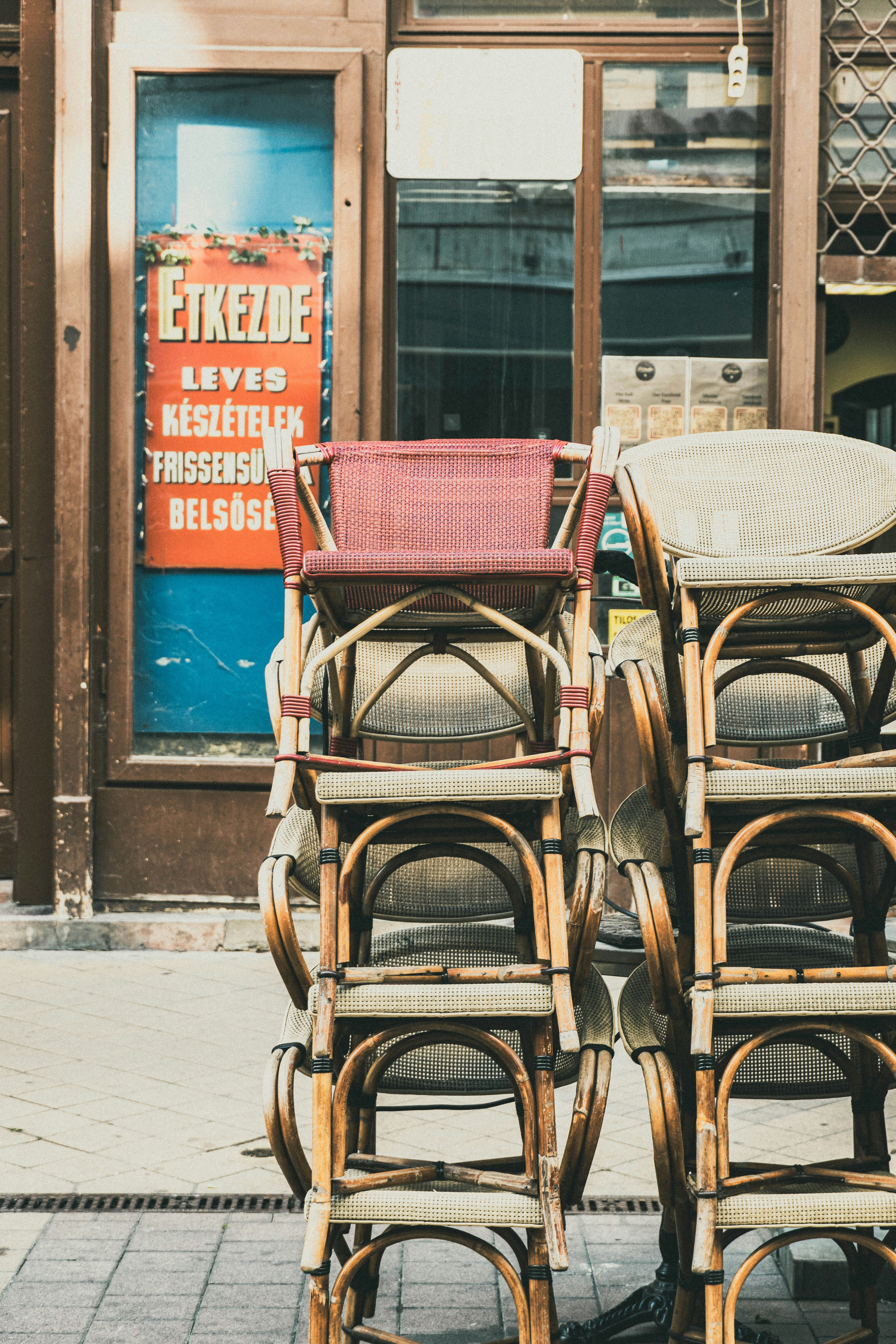 Stacked Café Chairs Framed by a Weathered Shopfront