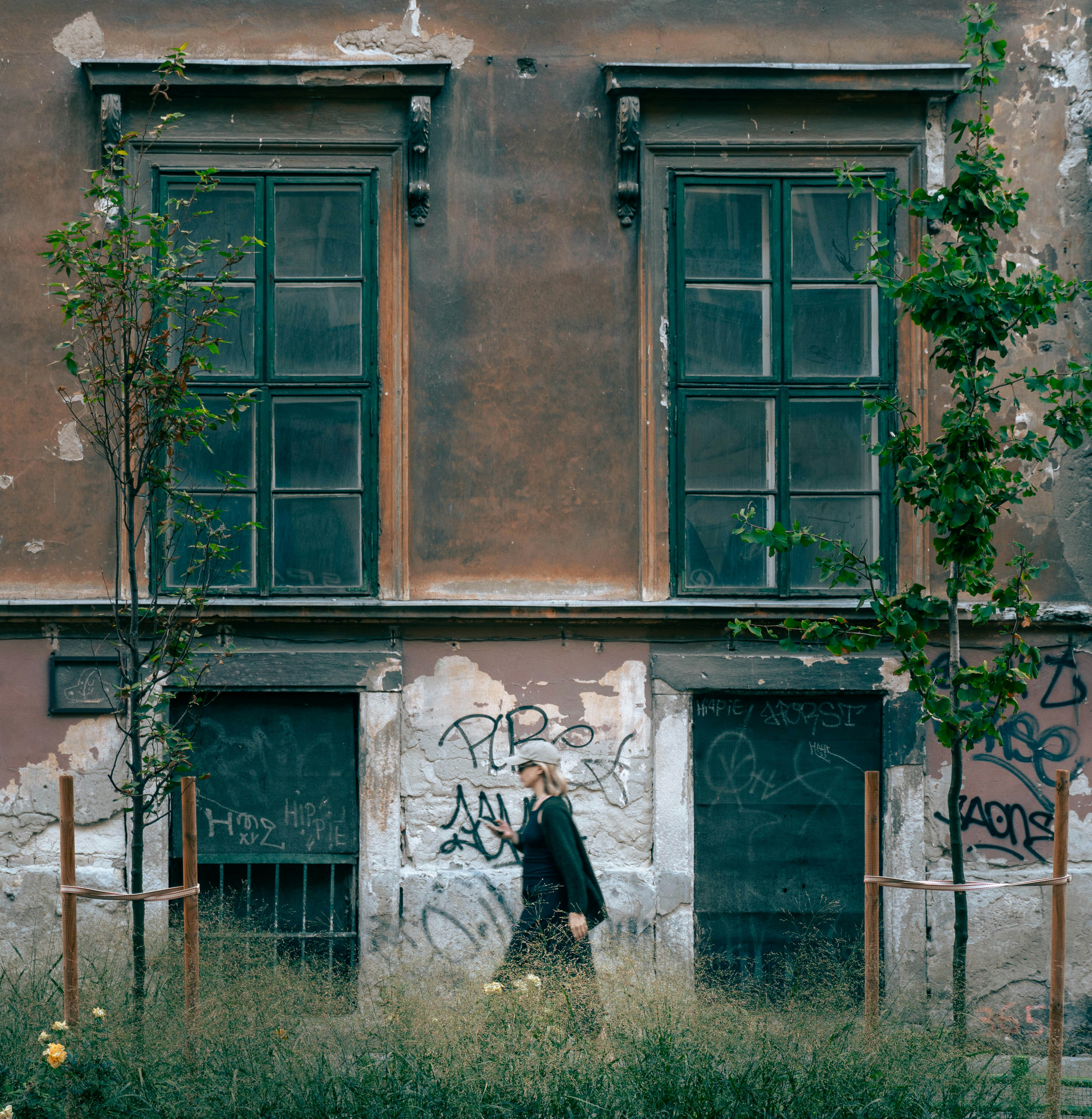 Wanderer in a Graffitied Facade Alley