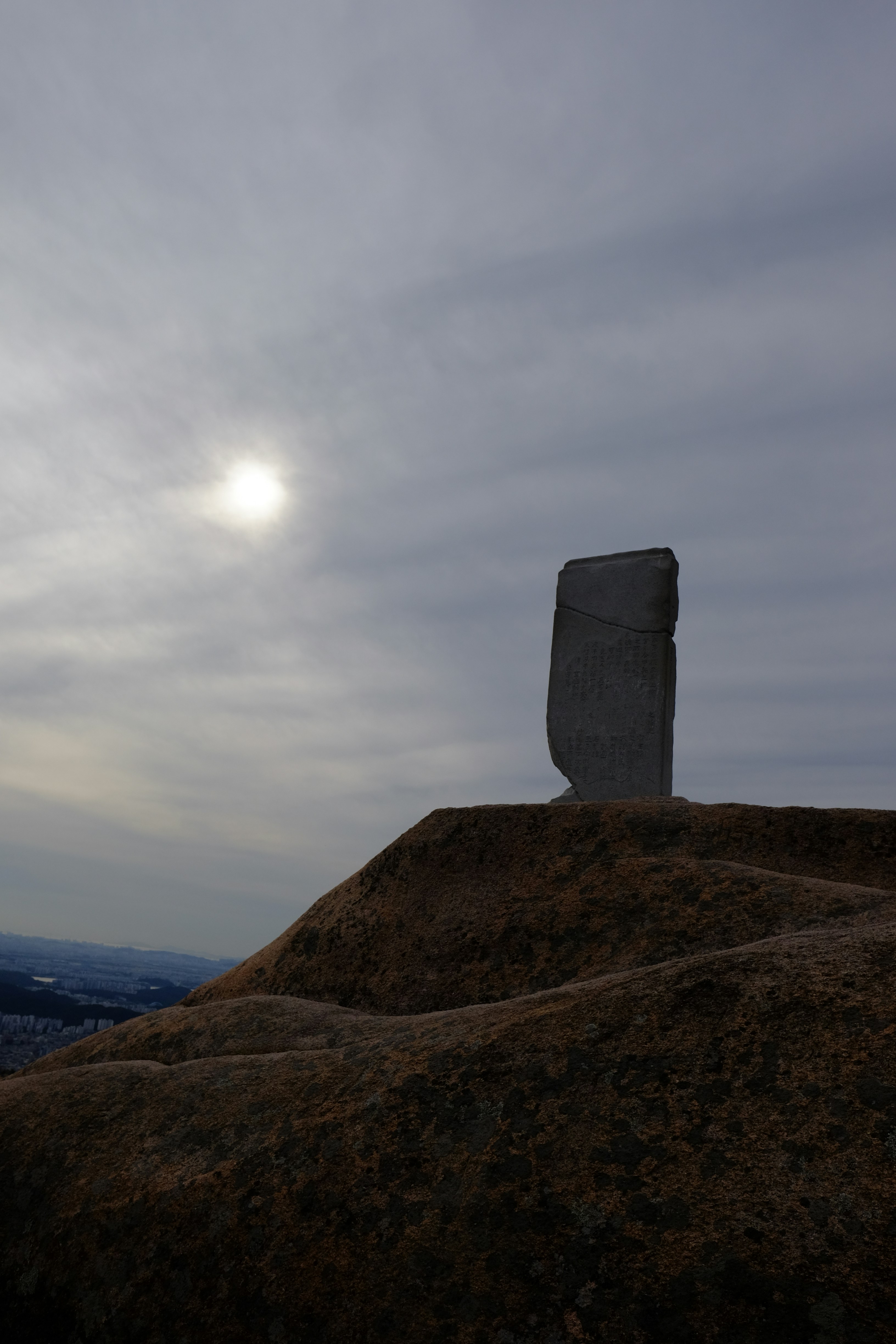Stone Monolith on Wind-Swept Ridge Under Overcast Sky