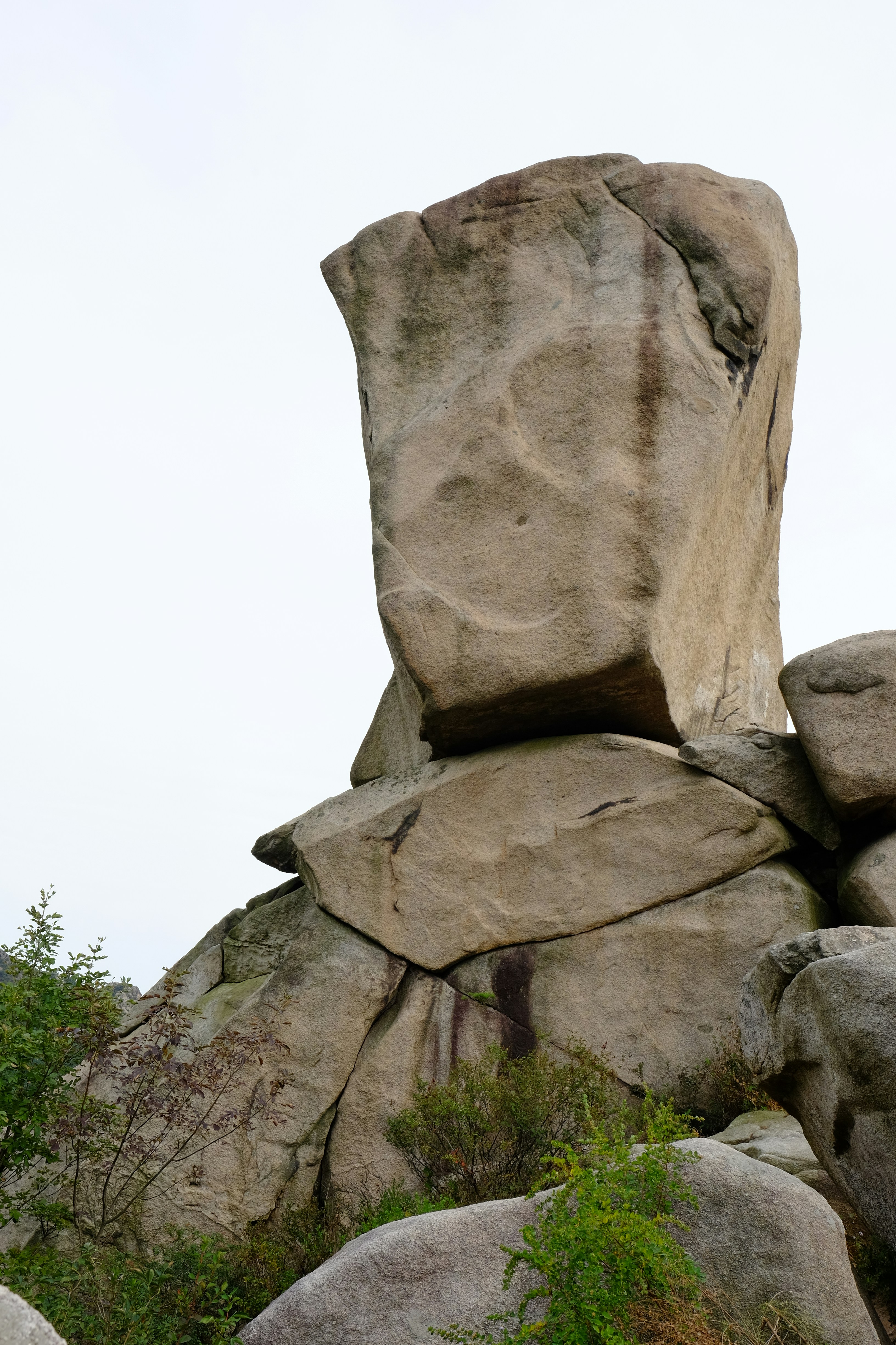 Monolithic Balance: A Towering Granite Sentinel Amid Sparse Scrub