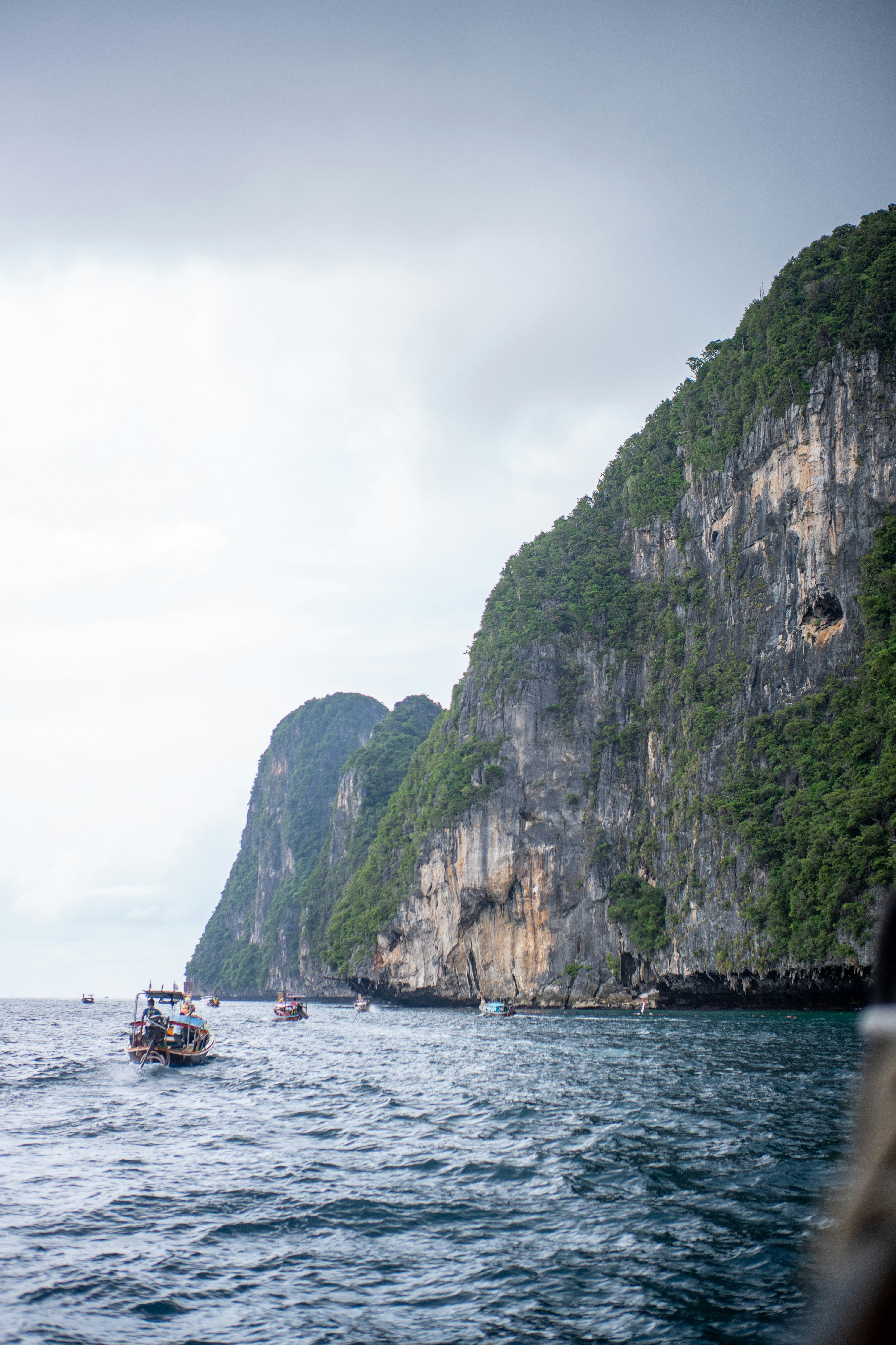 Cliffside Voyage: Boats Tread Lightly Along a Limestone Curtain