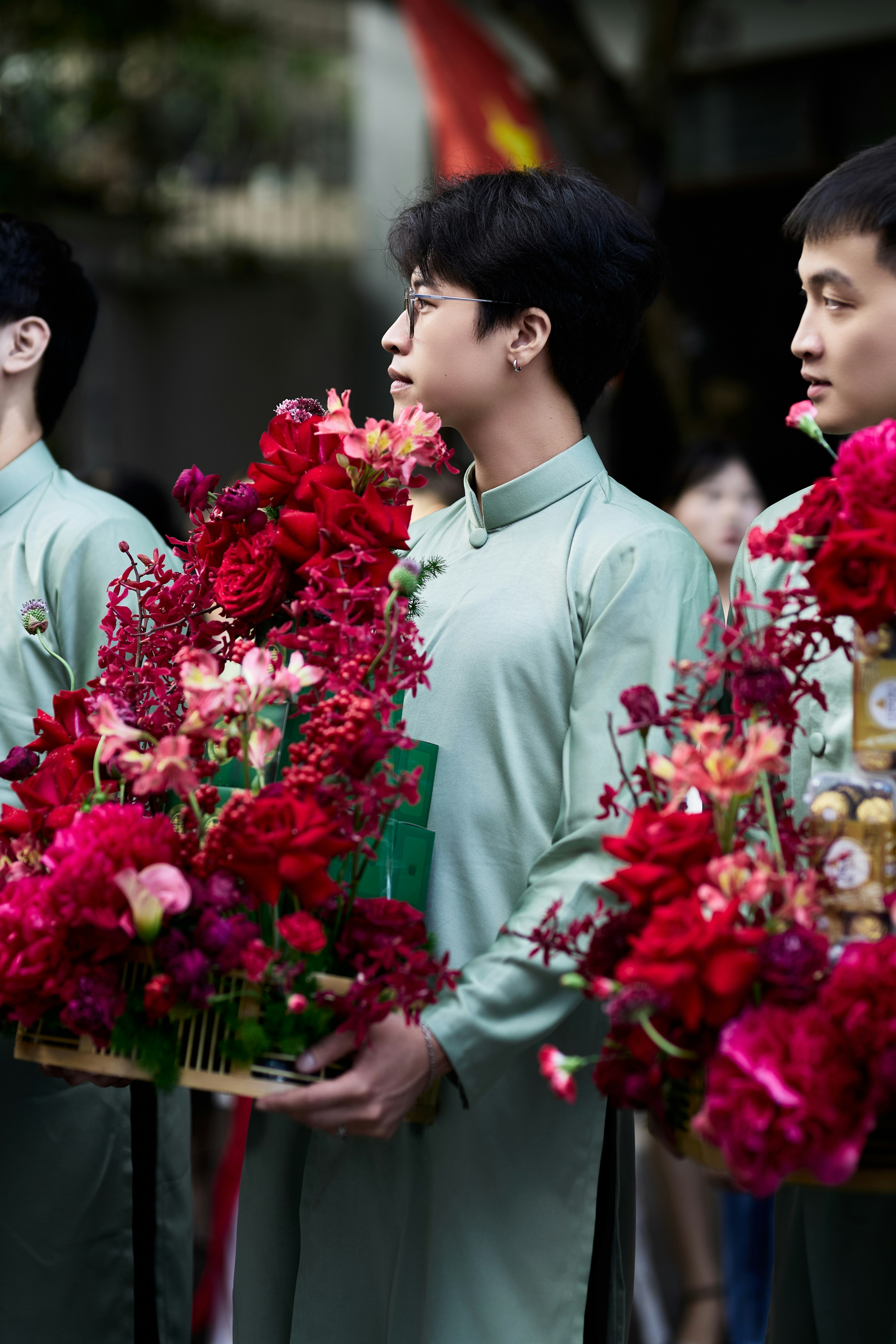Center of Calm Amid Color: A Student in Mint Áo Dài with Floral Confetti