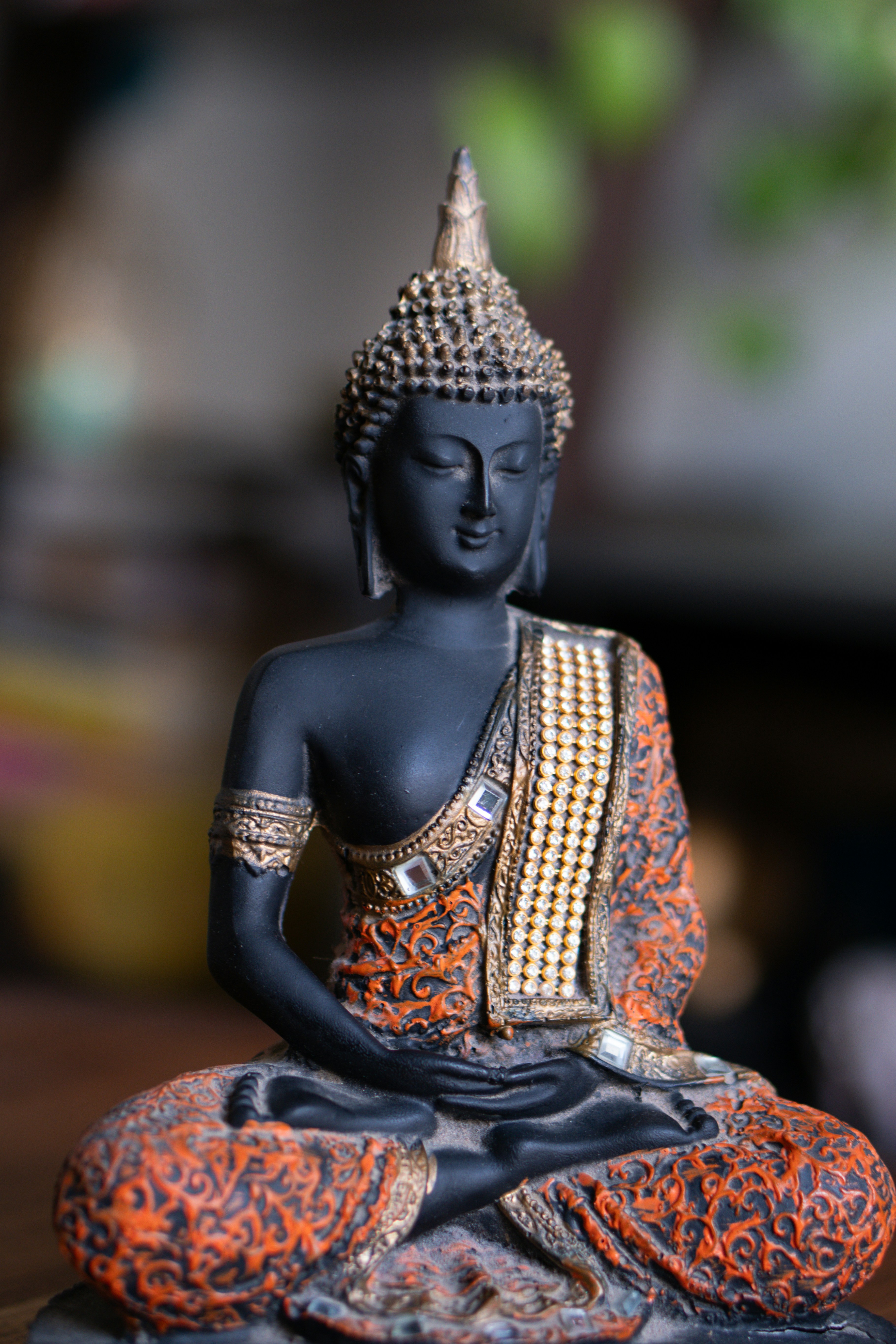 Meditative Silence: A Dark Buddha in Detailed Orange Robes