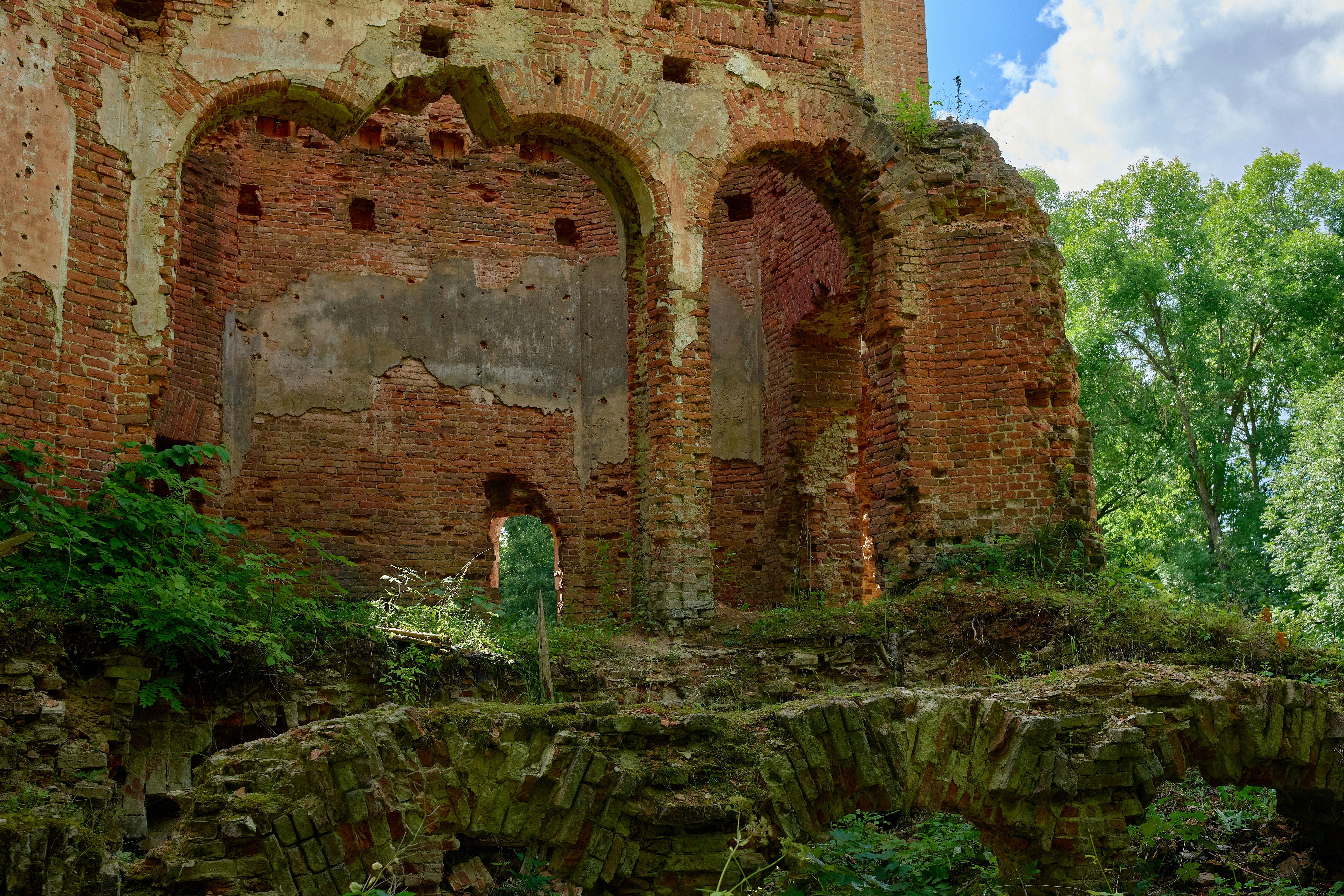 Sunlit Ruins: Weathered Arches Framed by Greenery