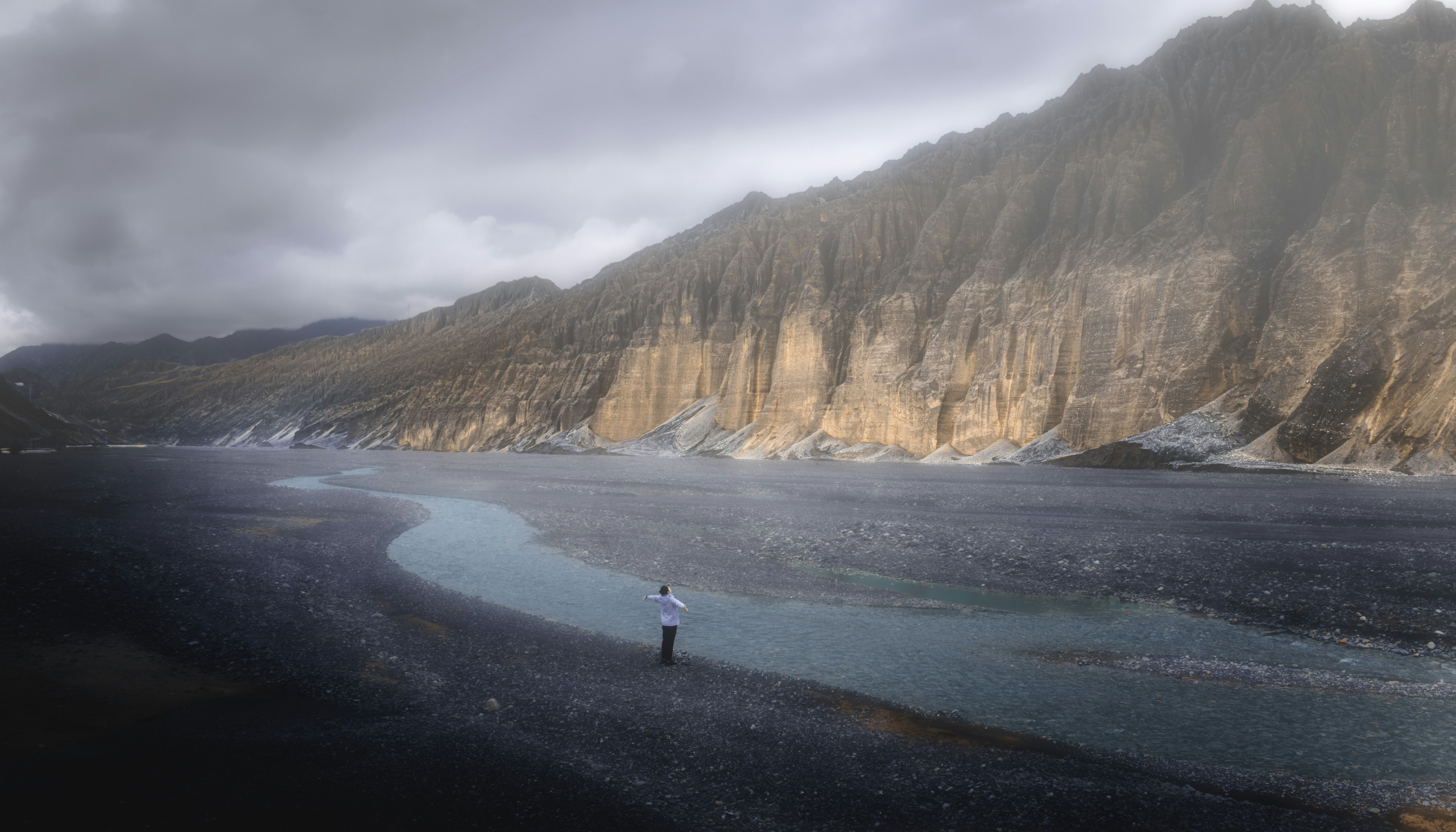 Tide-channel Crowned by Cliffs: A Lone Figure at the Water’s Edge