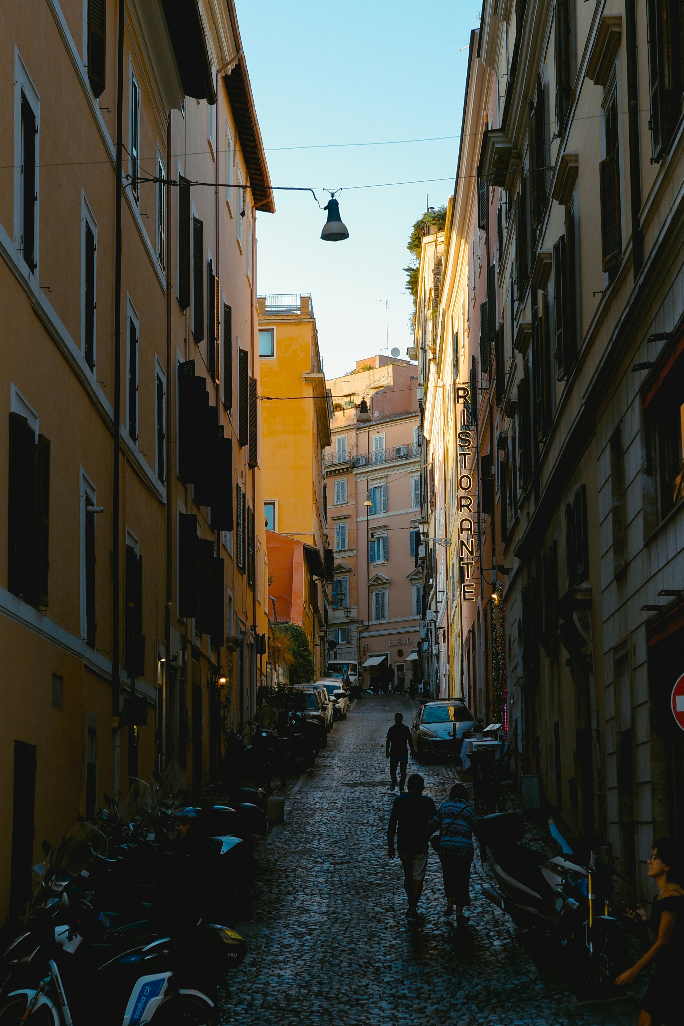 Sunlit alleyway descent toward a quiet street