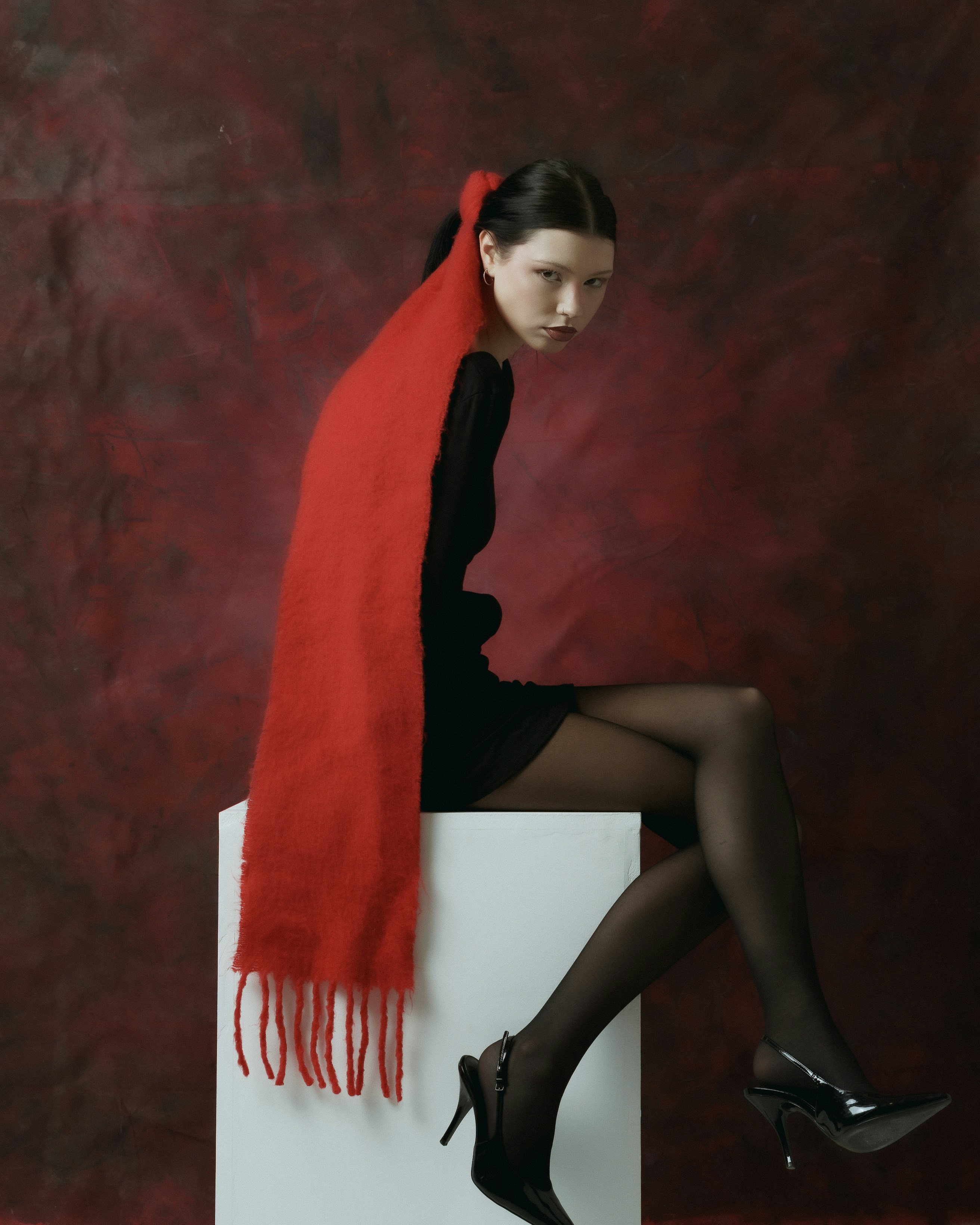 Red scarf, poised gaze: a contemporary chiaroscuro moment