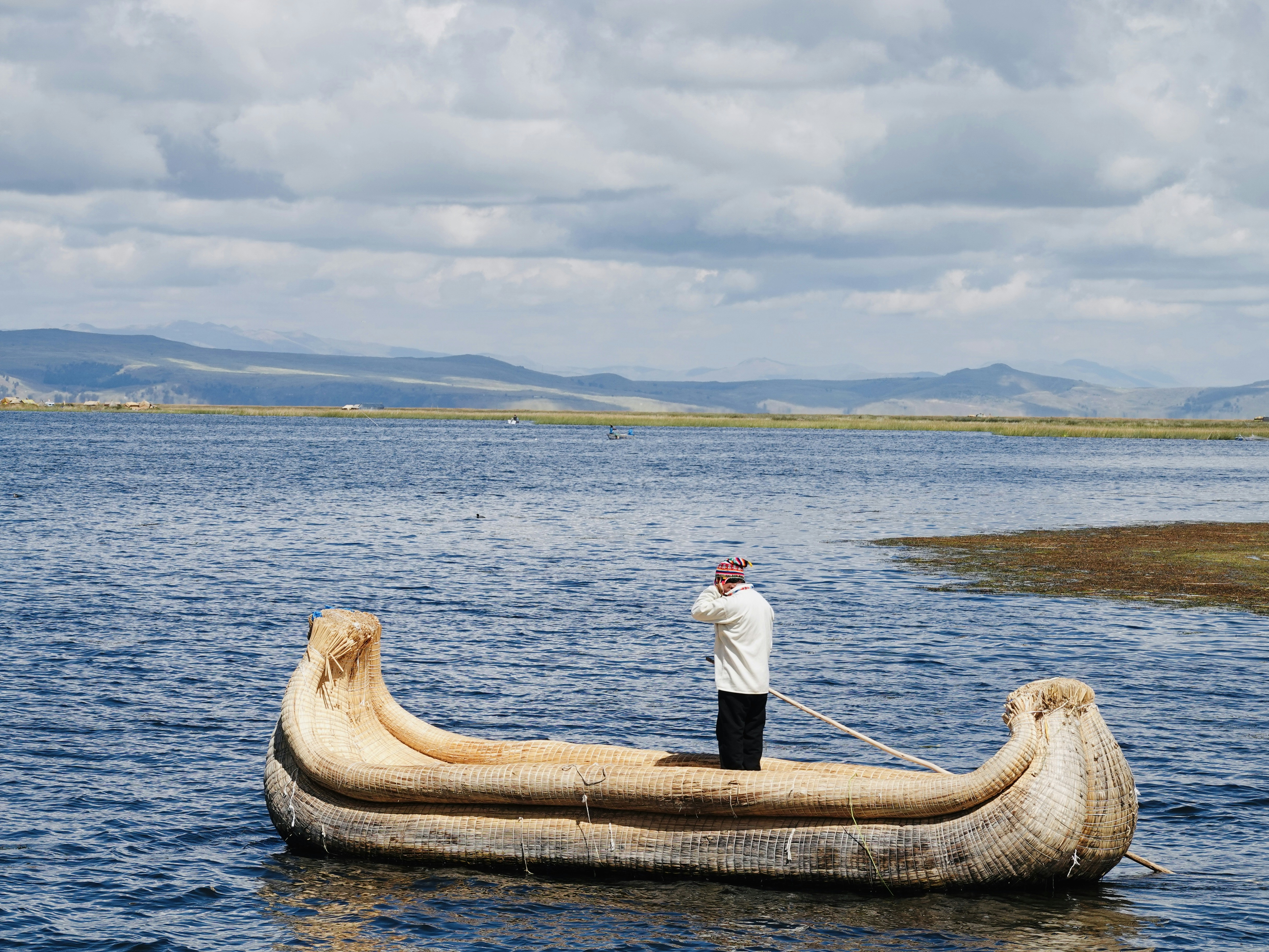 A lone boatman at the edge of a vast lake