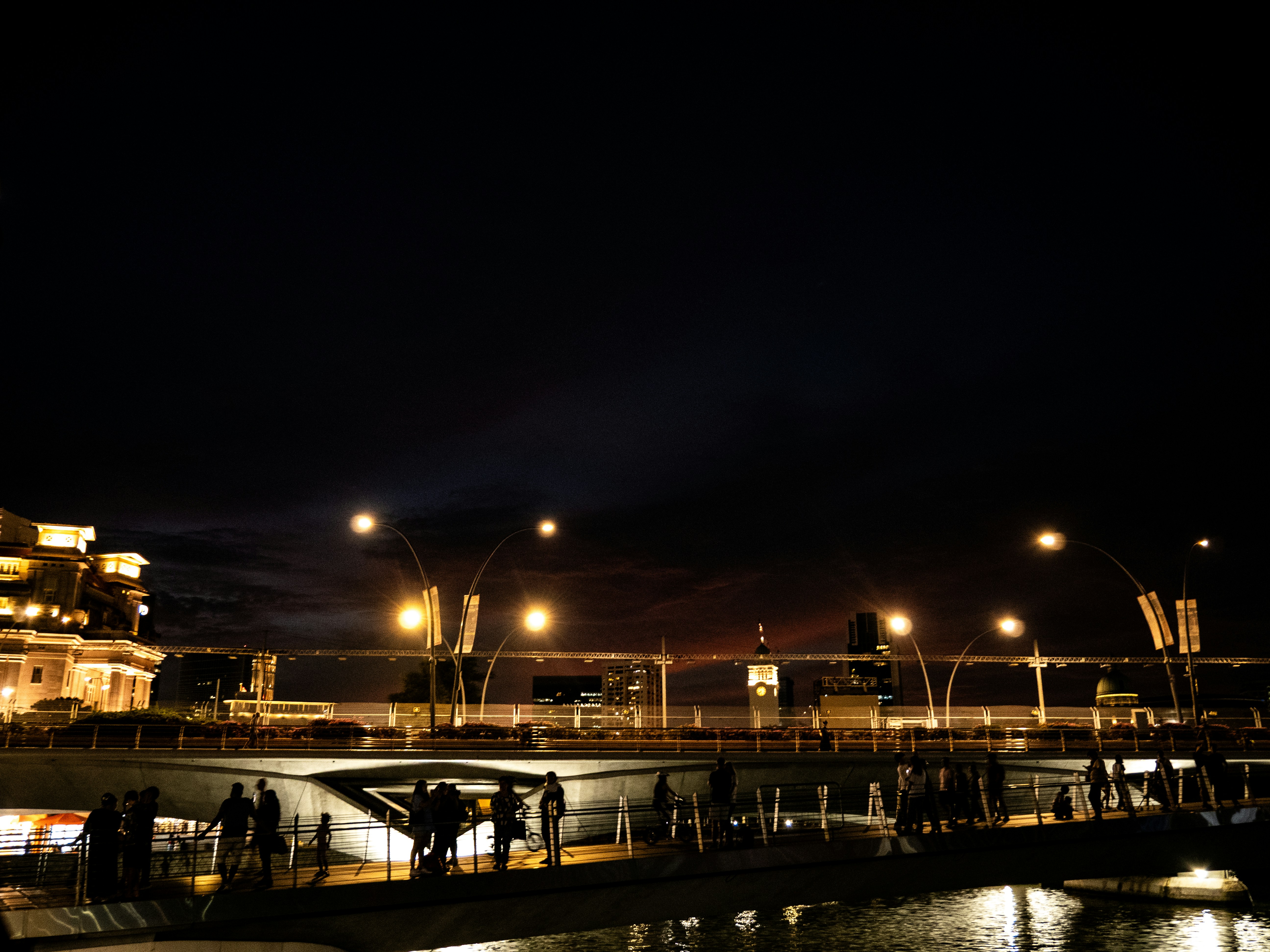 Nighttime Riverside Promenade: Quiet Figures by the Water's Edge