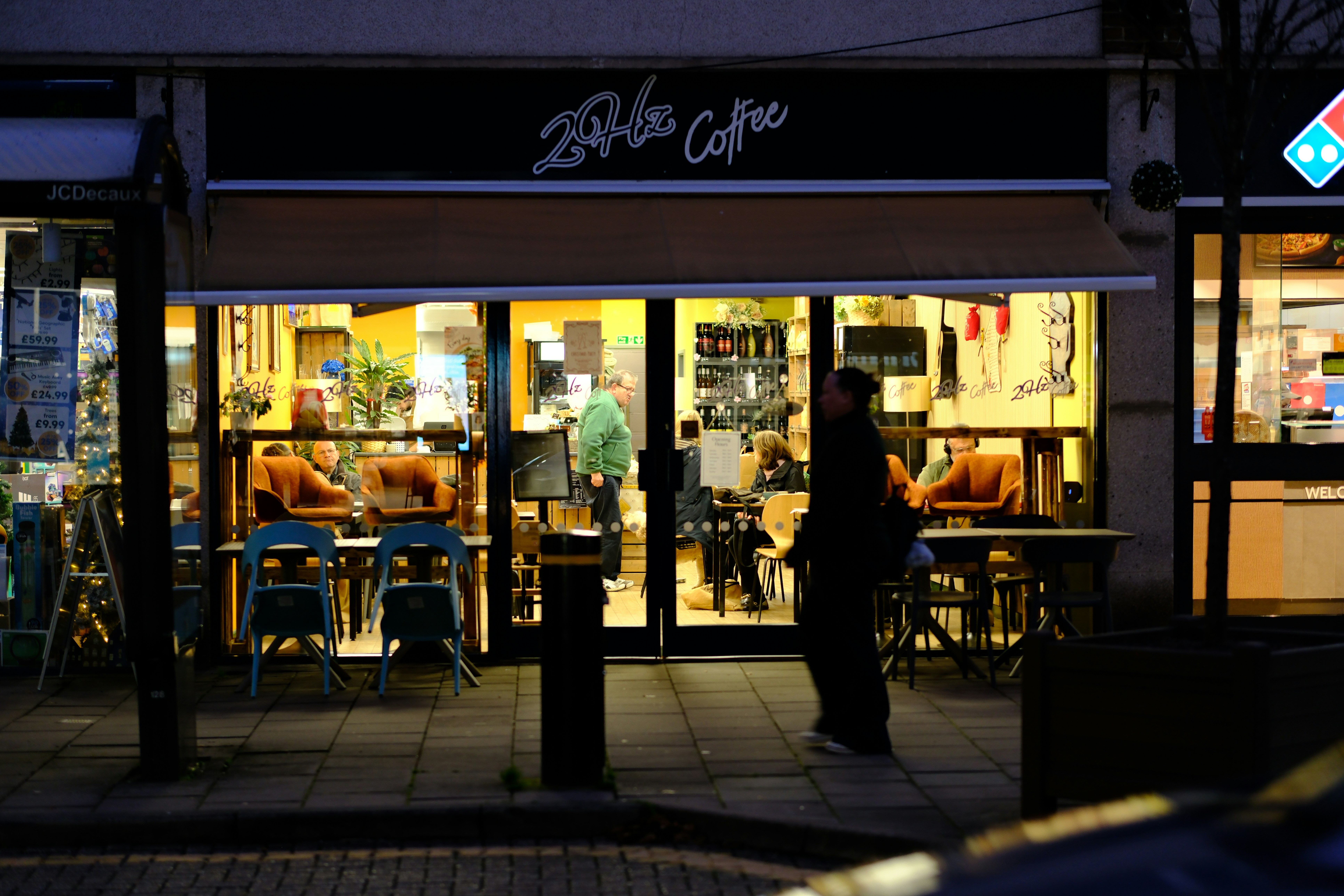 Evening Espresso: Quiet Café Glow Through Streetfront Glass