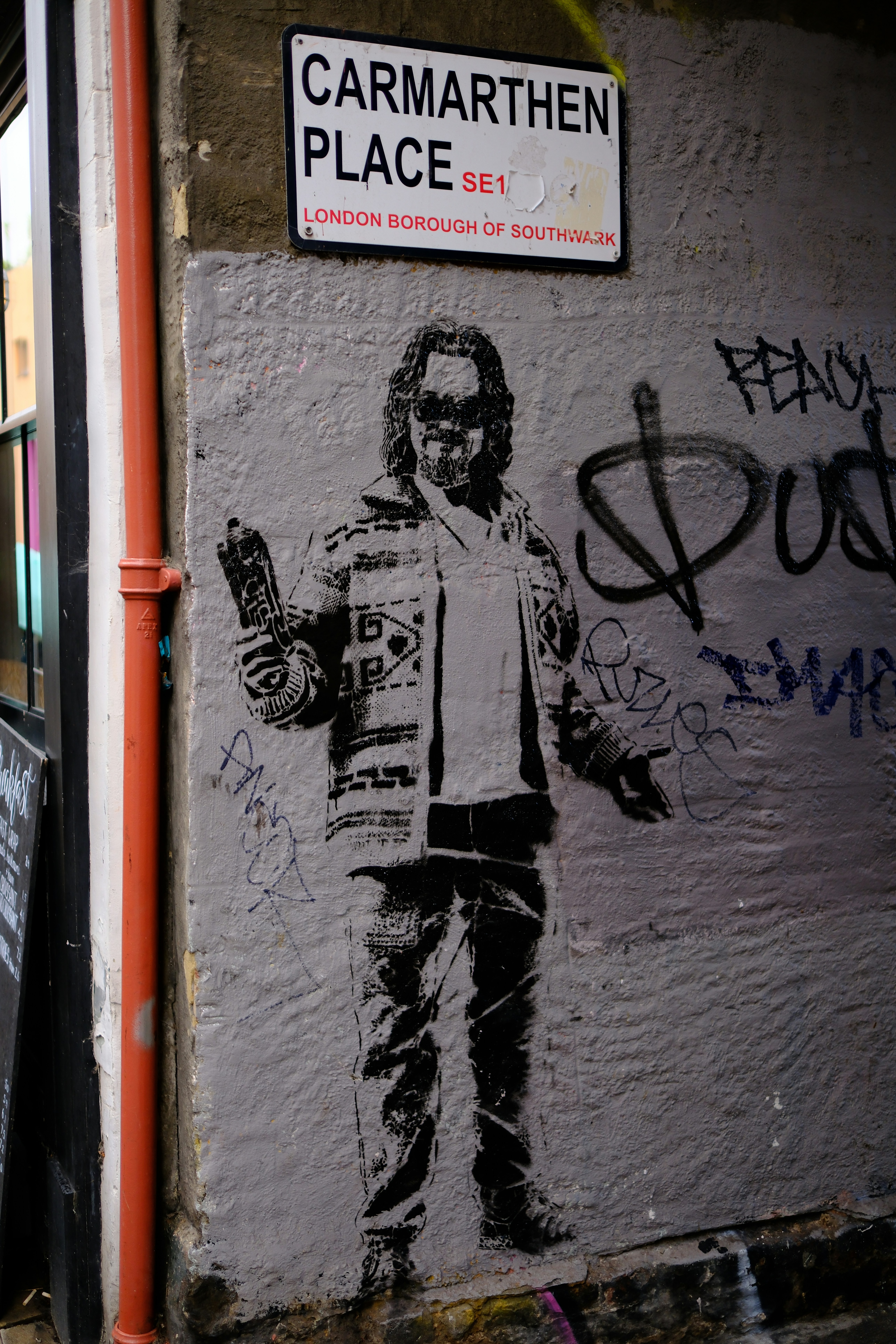 Graffiti John: A Rebel Silhouette Anchored by London Street Sign