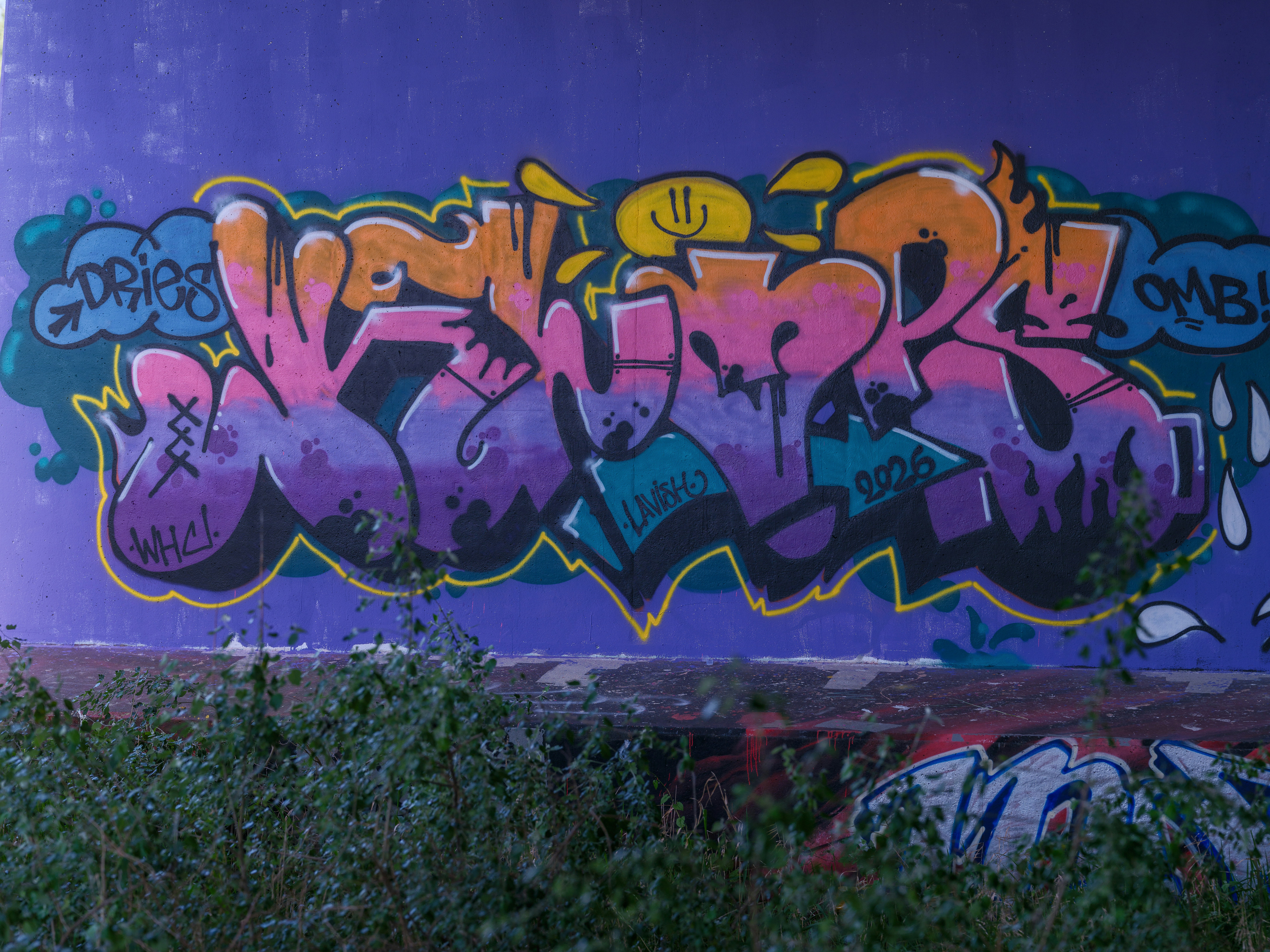 Vivid Graffiti Mosaic on a Weathered Purple Wall