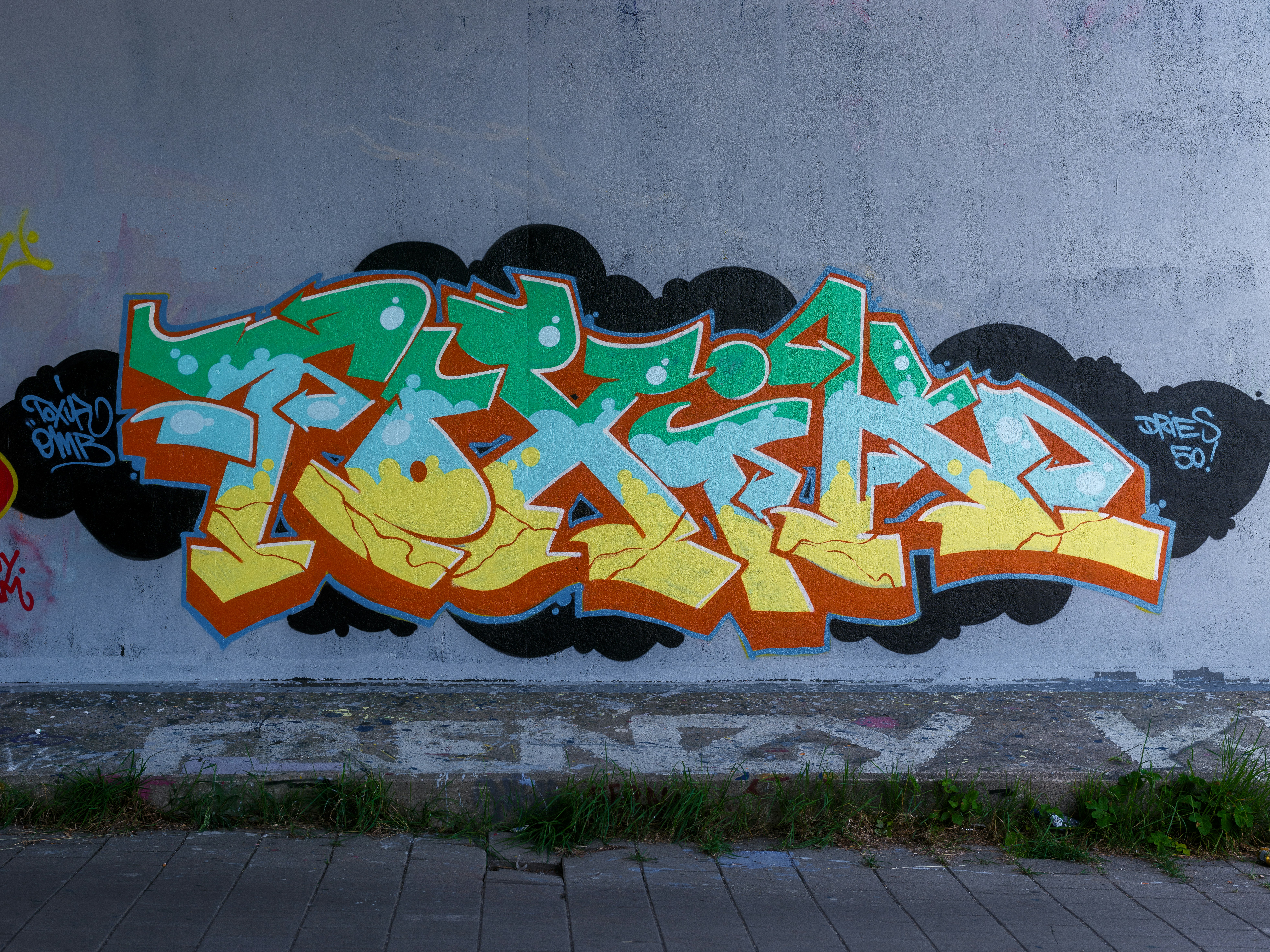 Vibrant Graffiti Chorus Across a Weathered Wall