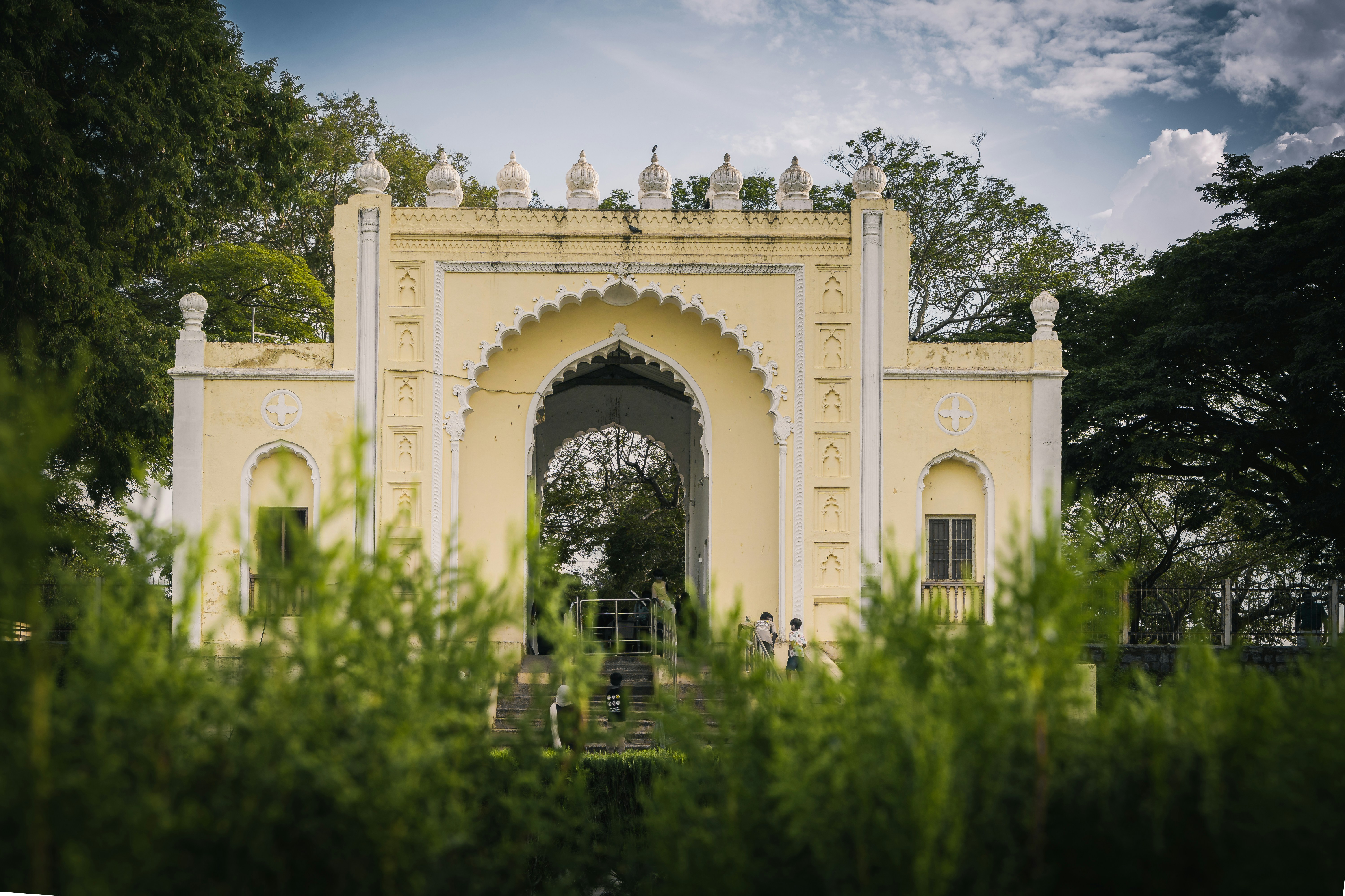 Sunlit Archway Gate Framed by Greenery in a Quiet Park