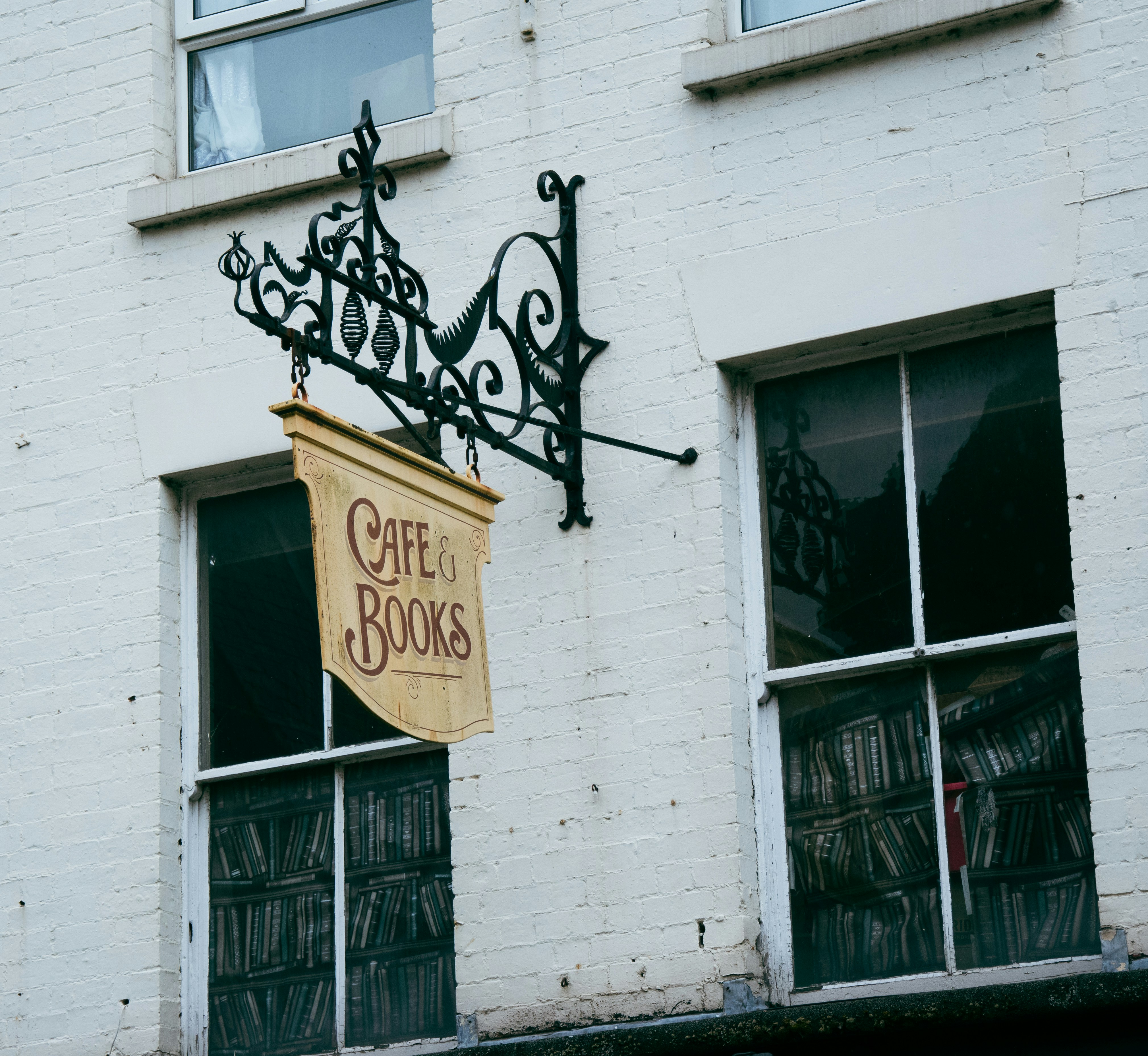 Iron Sign, White Facade, and a Peek Through Windows