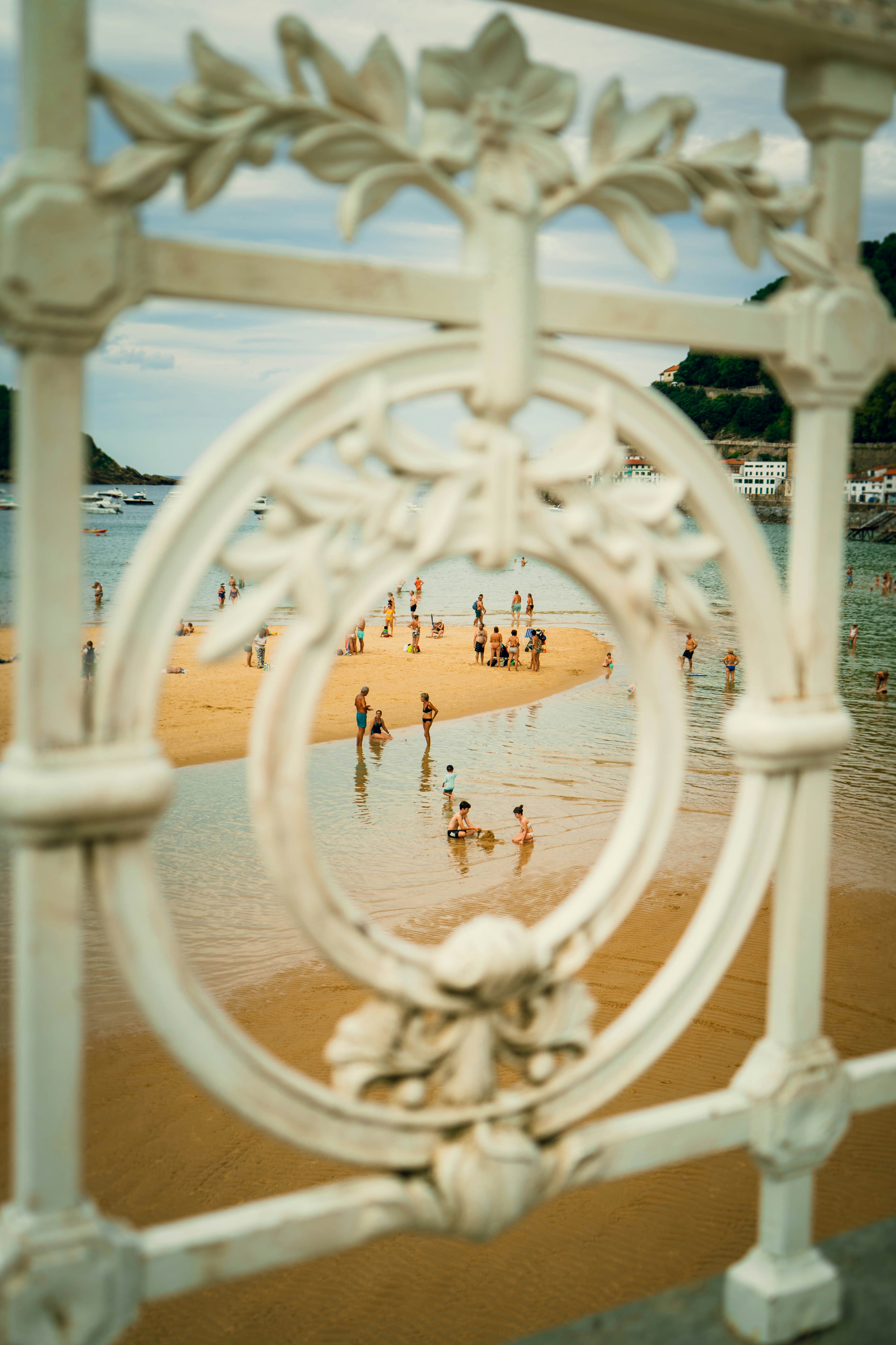 Framed by Ornament: Beachgoers Seen Through a Circular Gate