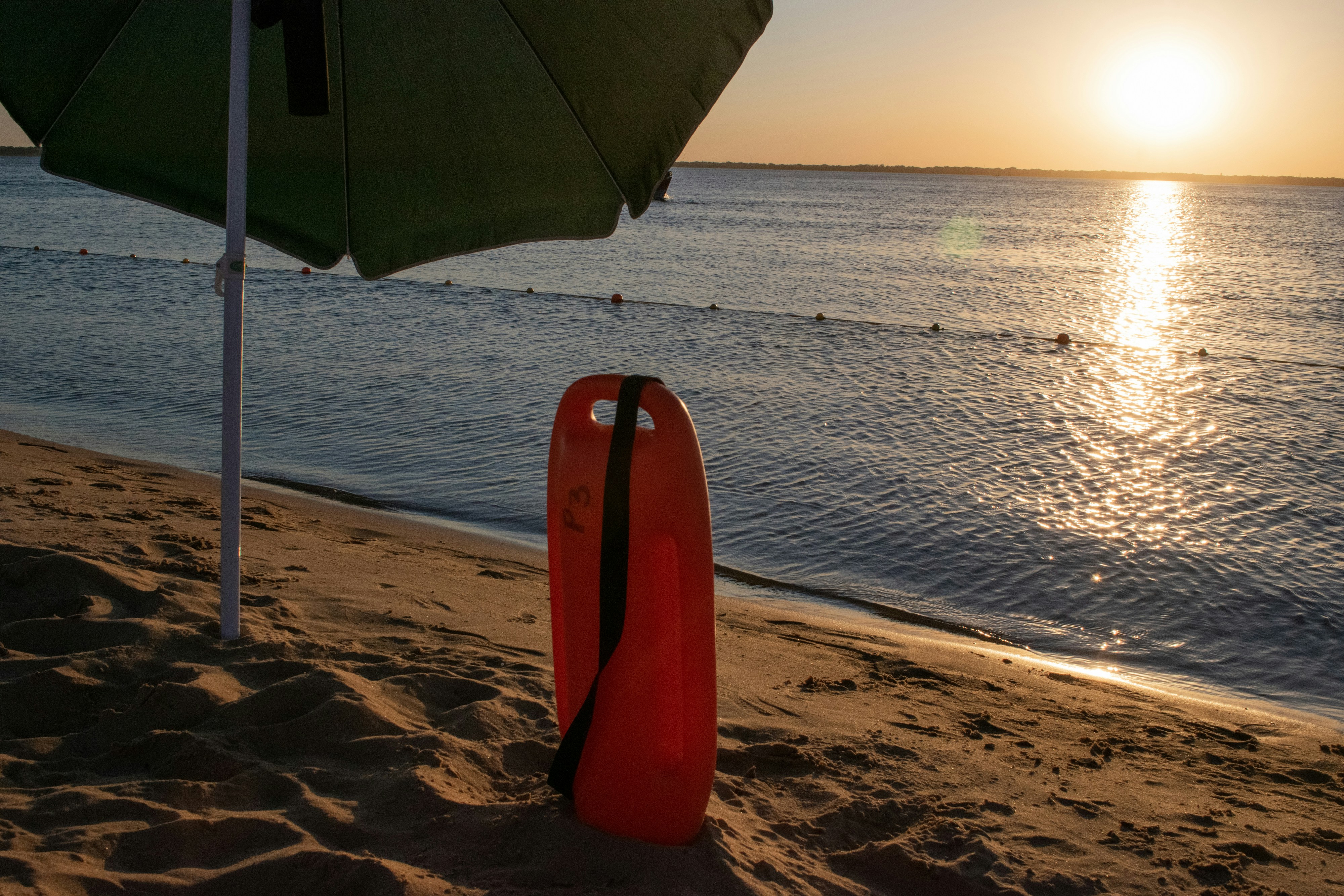 Sunlit Lifebuoy at the Quiet Beach Edge