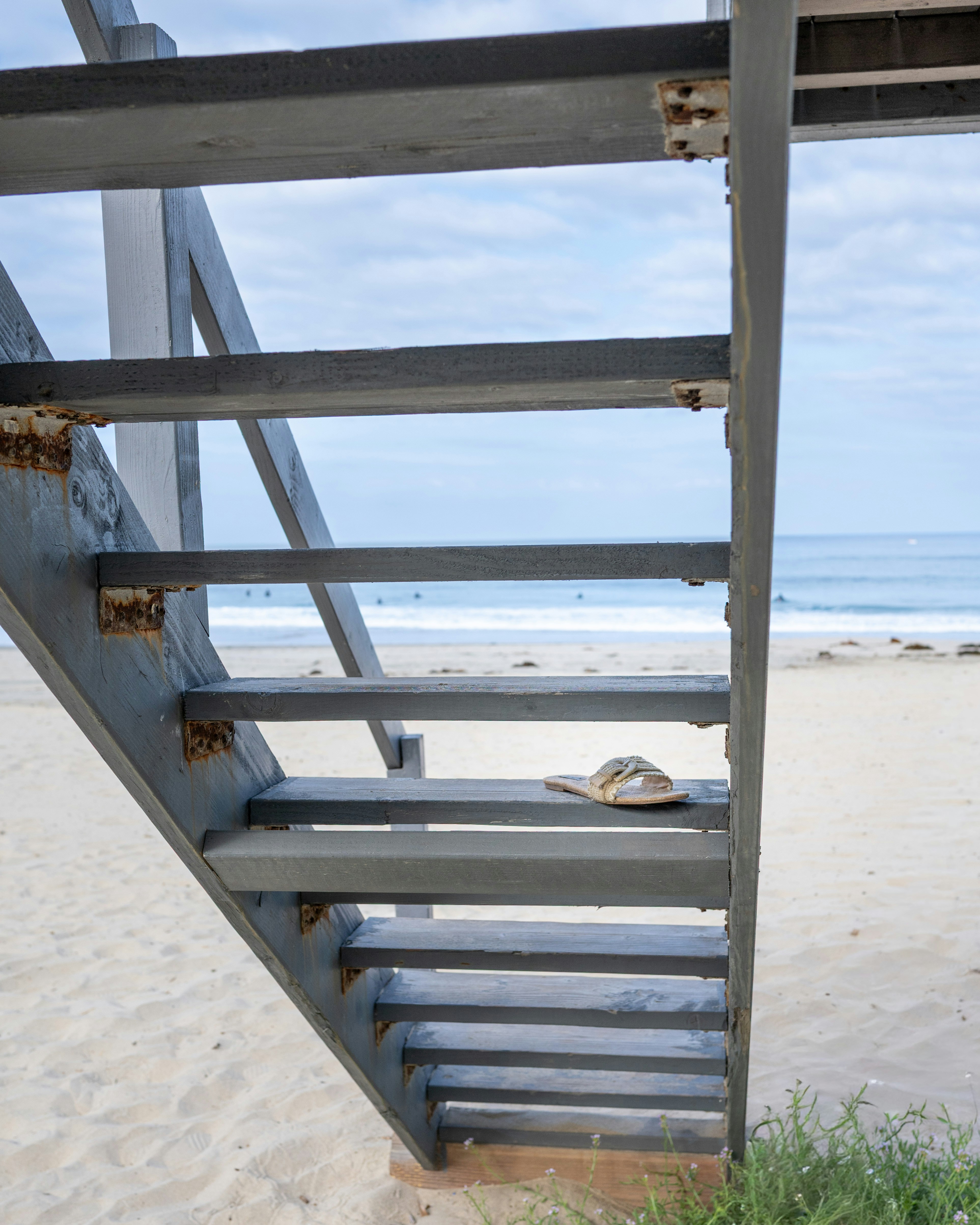 Weathered Staircase to the Shore: Framing the Beach Through Rust and Sky