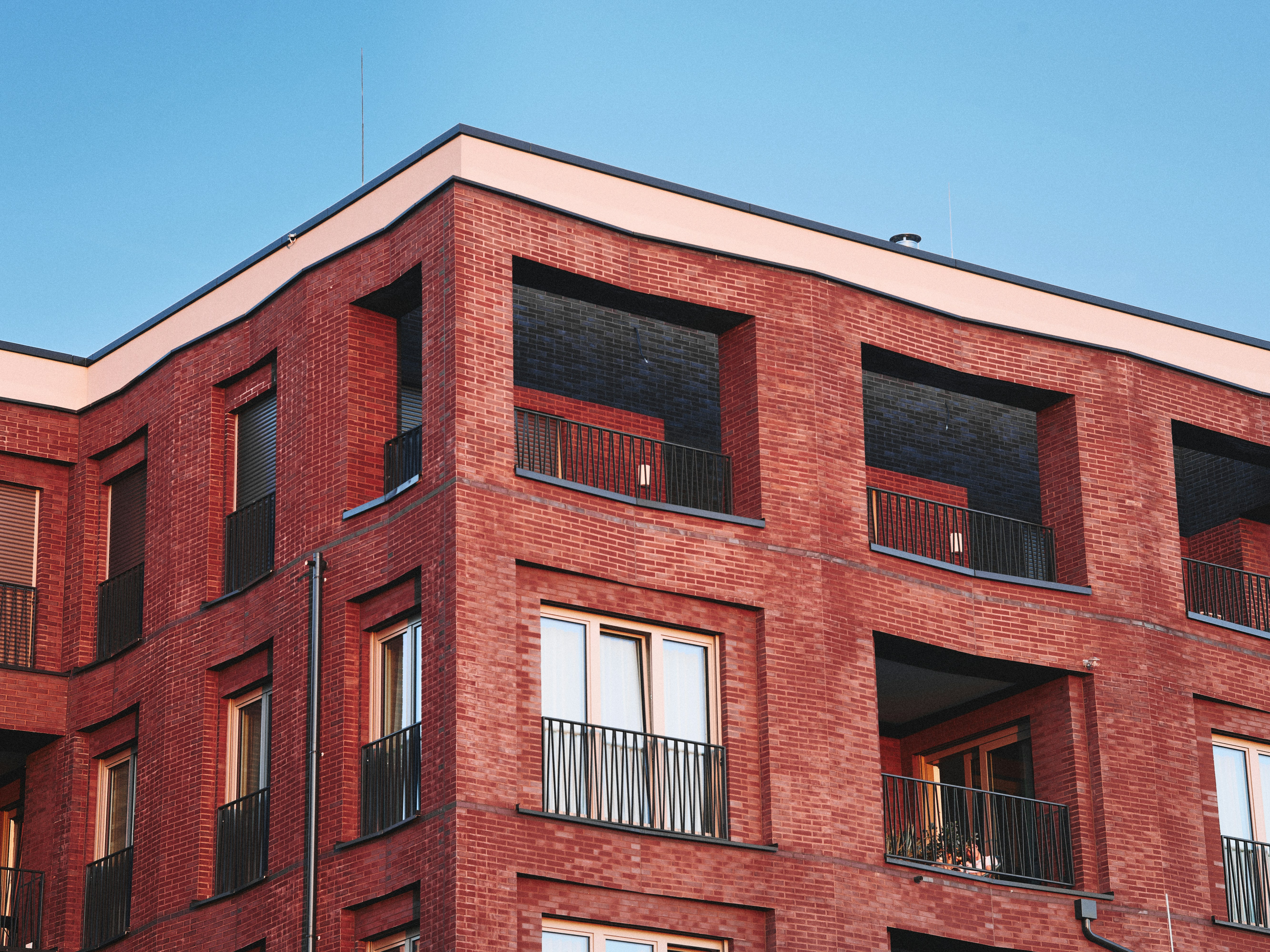 Red Brick apartment façade under a crisp blue sky