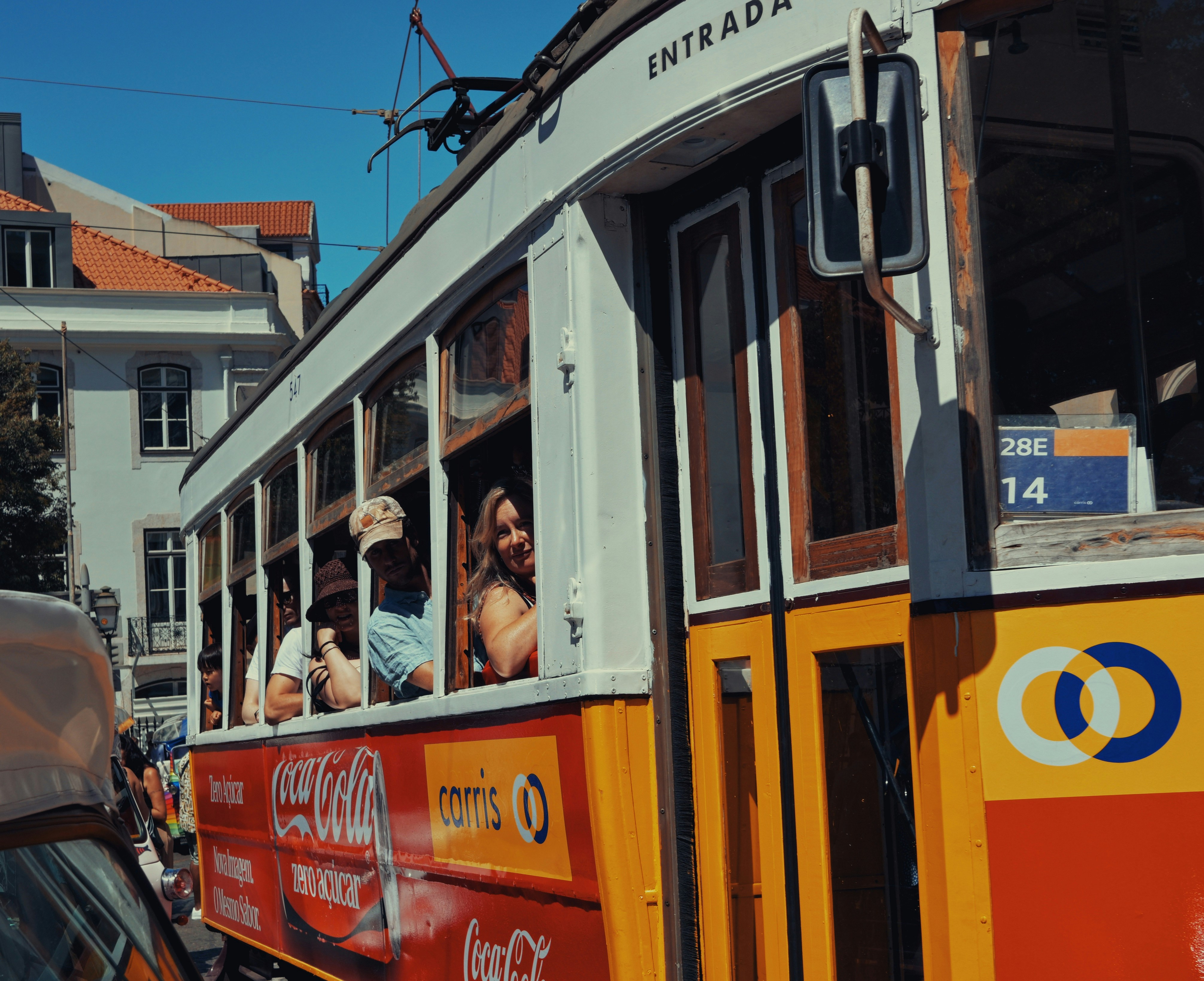 Sunlit tram glimpse: passengers peering from a vintage city ride