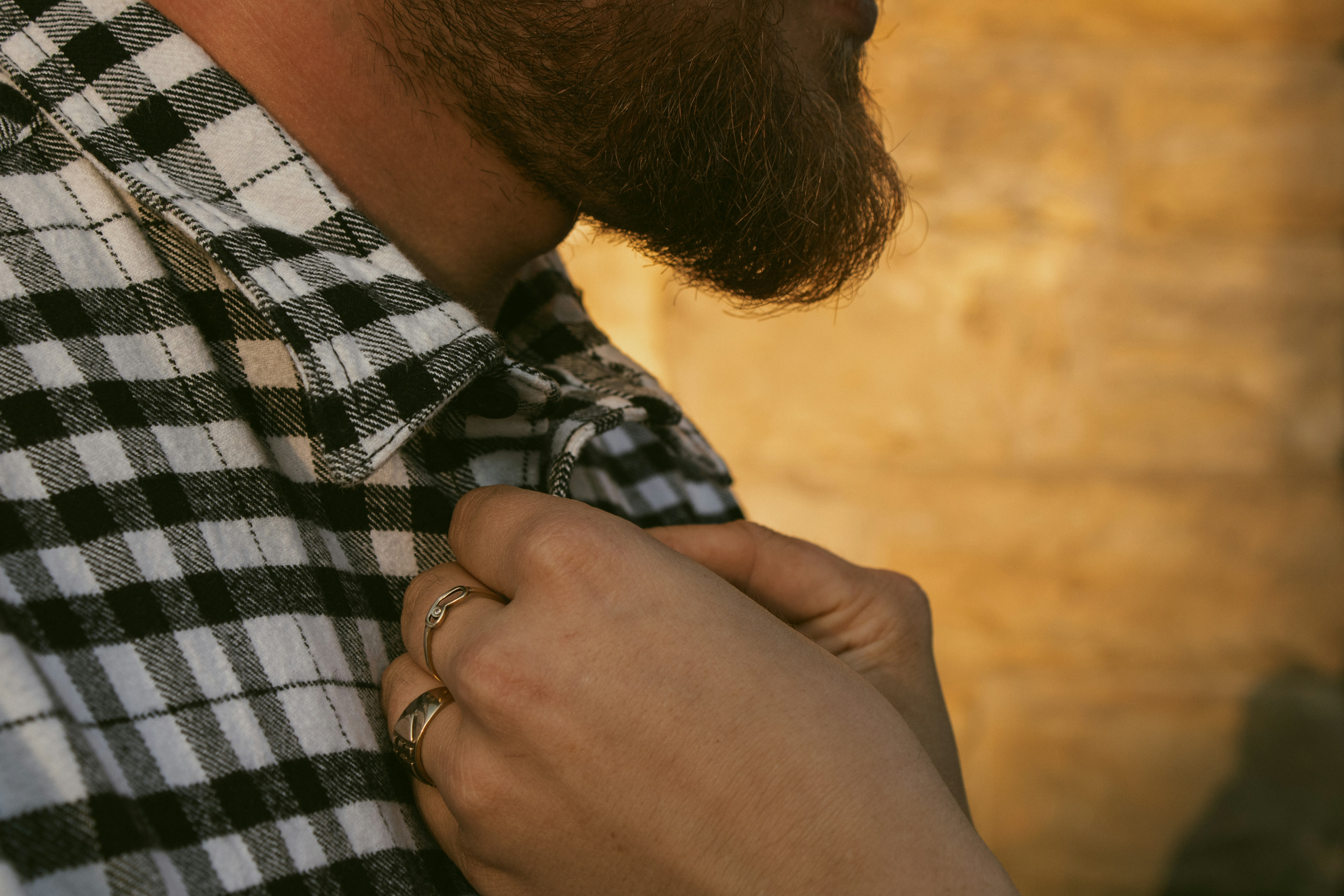 Beard and plaid: a quiet moment of tying a shirt