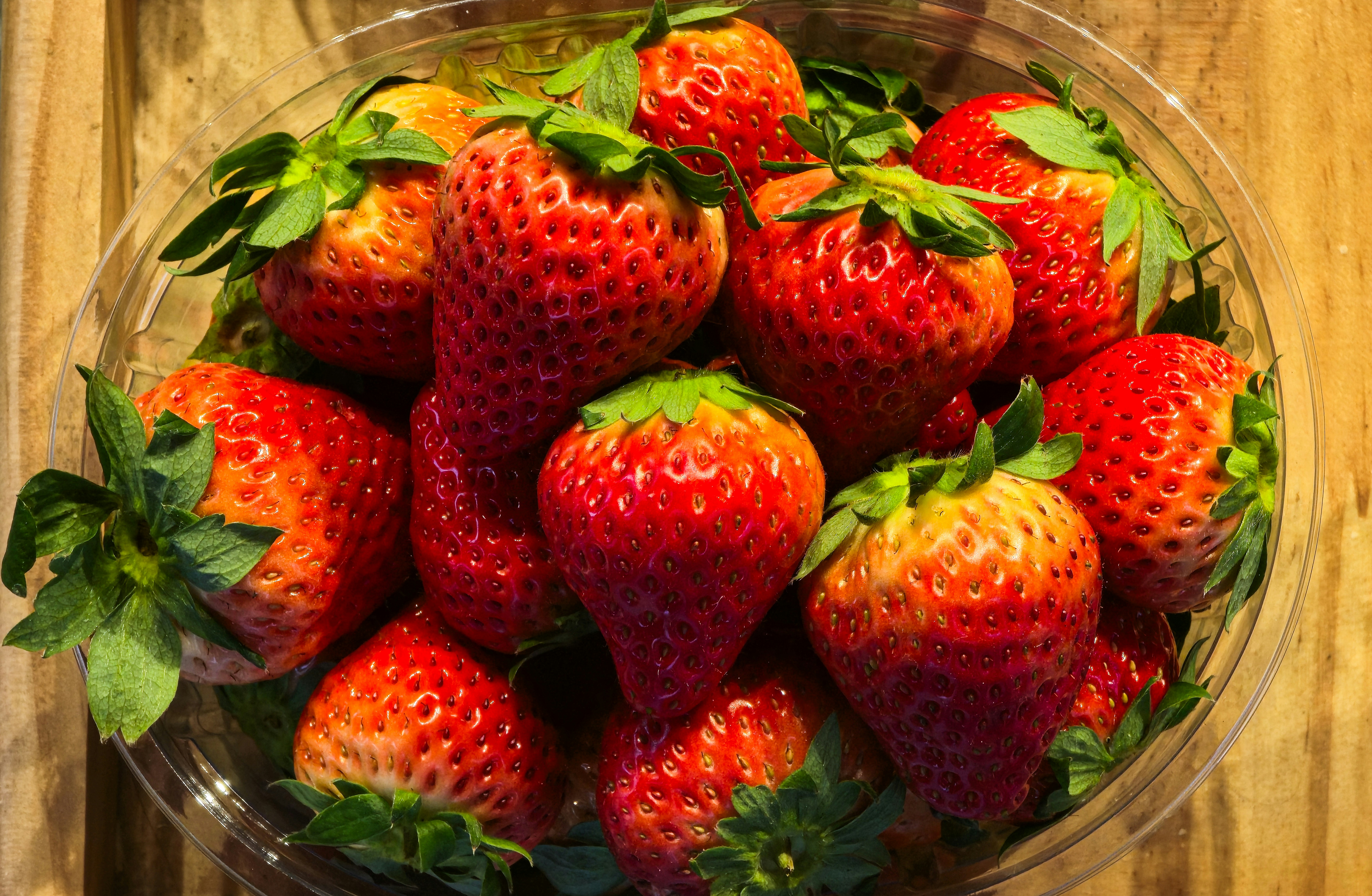 Ruby Harvest: Close‑Up of Sunlit Strawberries in Glass Bowl